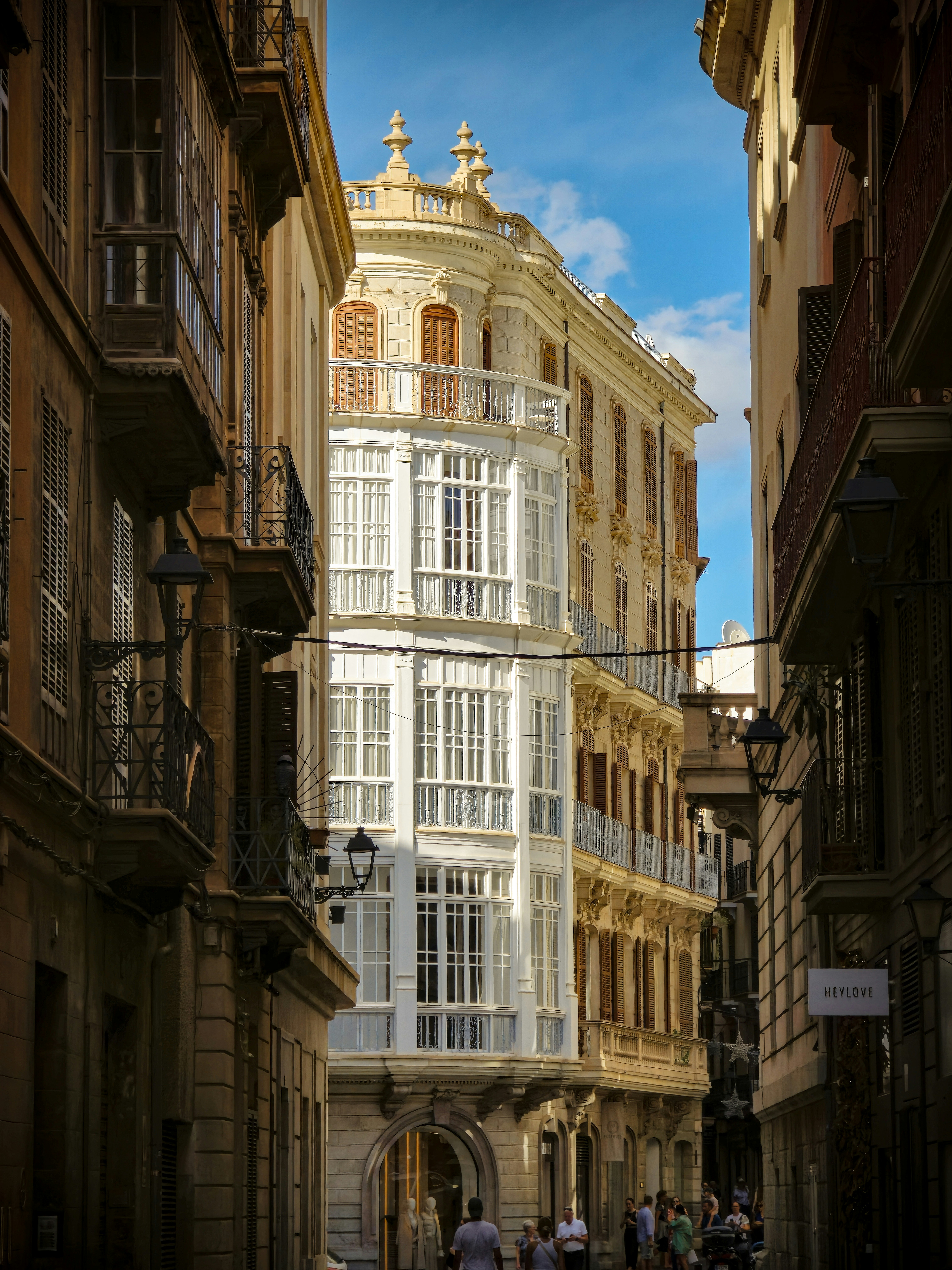 Sunlit Arcade: A European Street Bordered by Ornate Façades