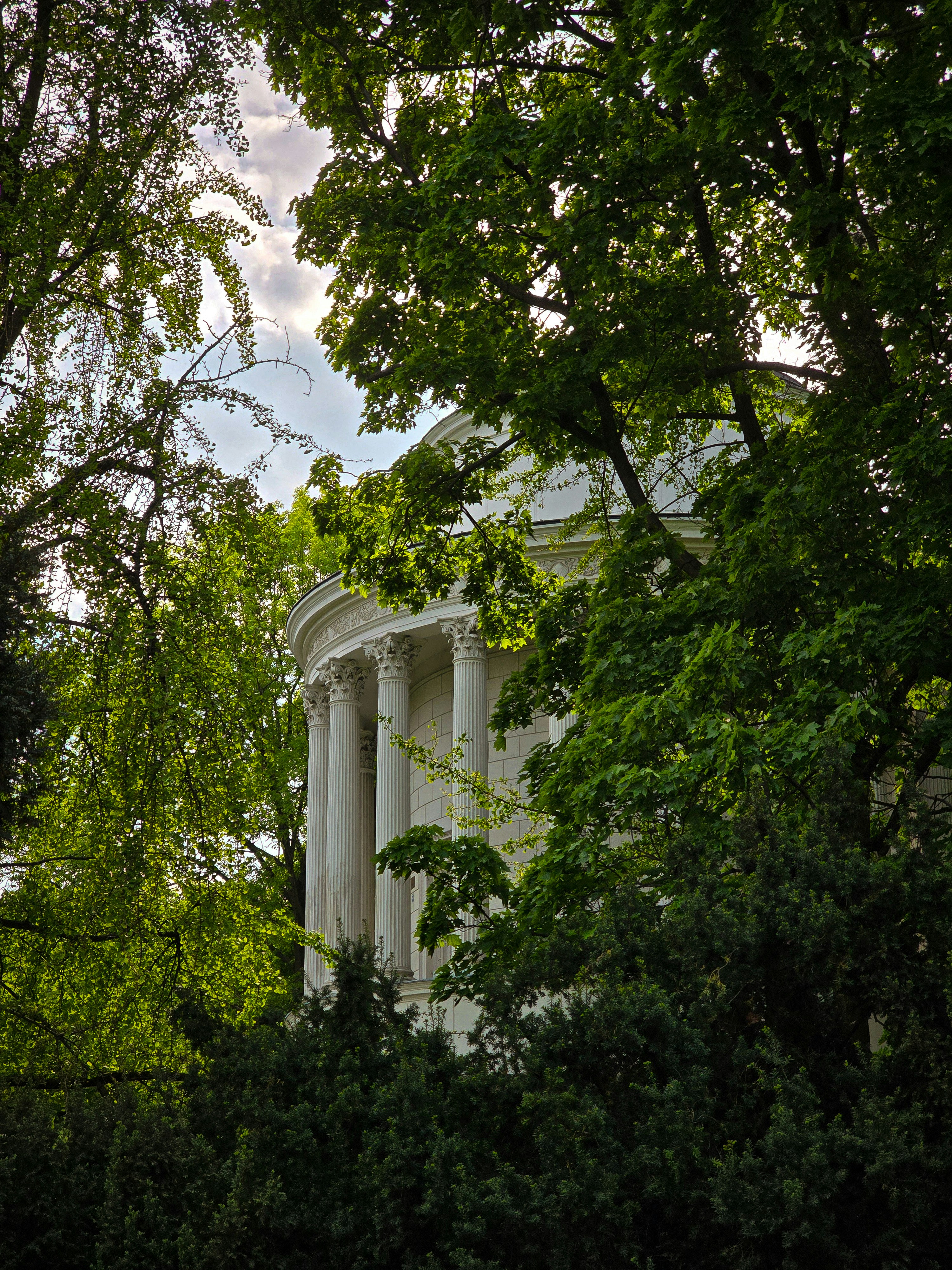 Neoclassical Temple Emerges Through Spring Canopy
