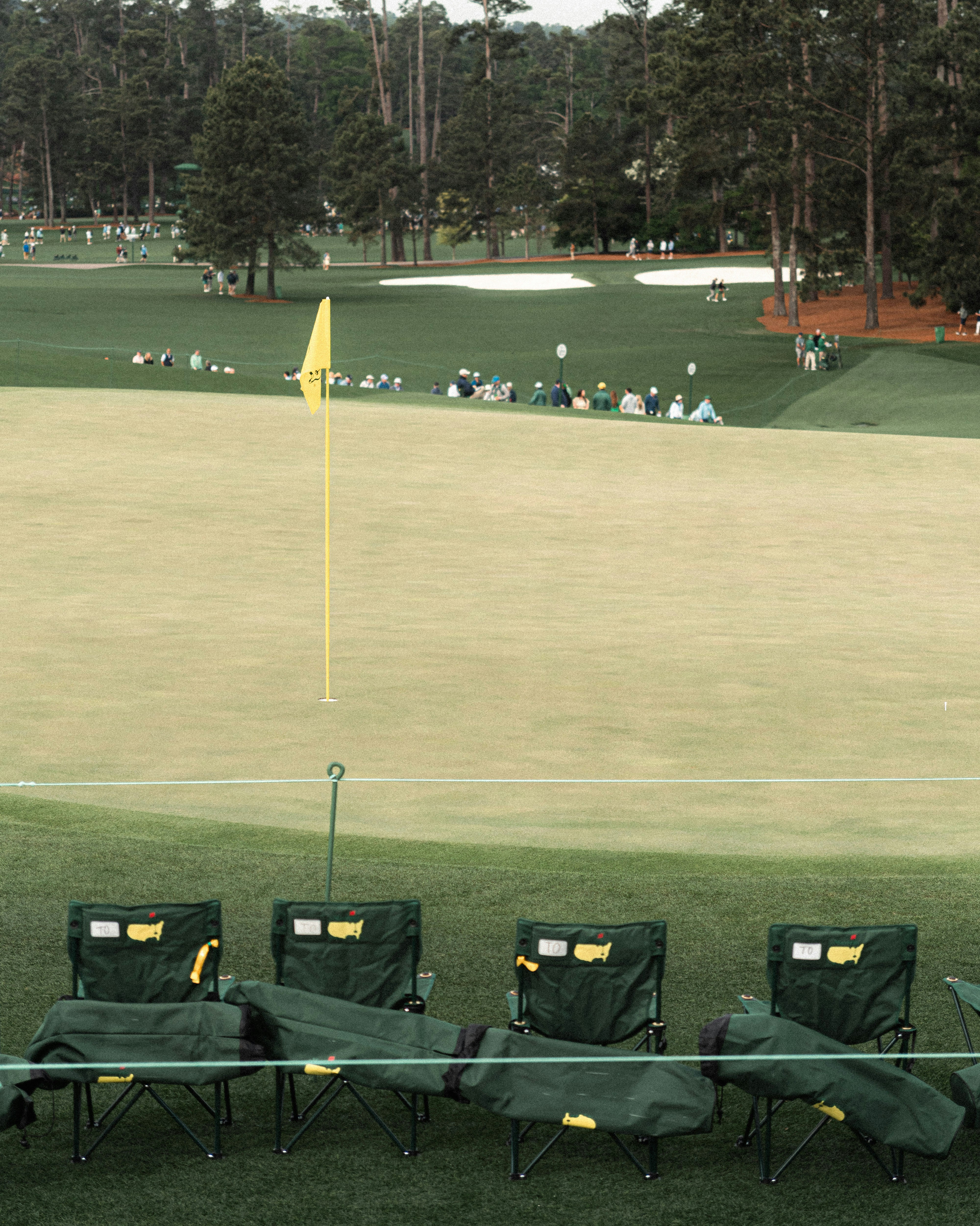 Yellow Flag, Green Greenery: A Golf Scene Framed from the Tee to the Chairs