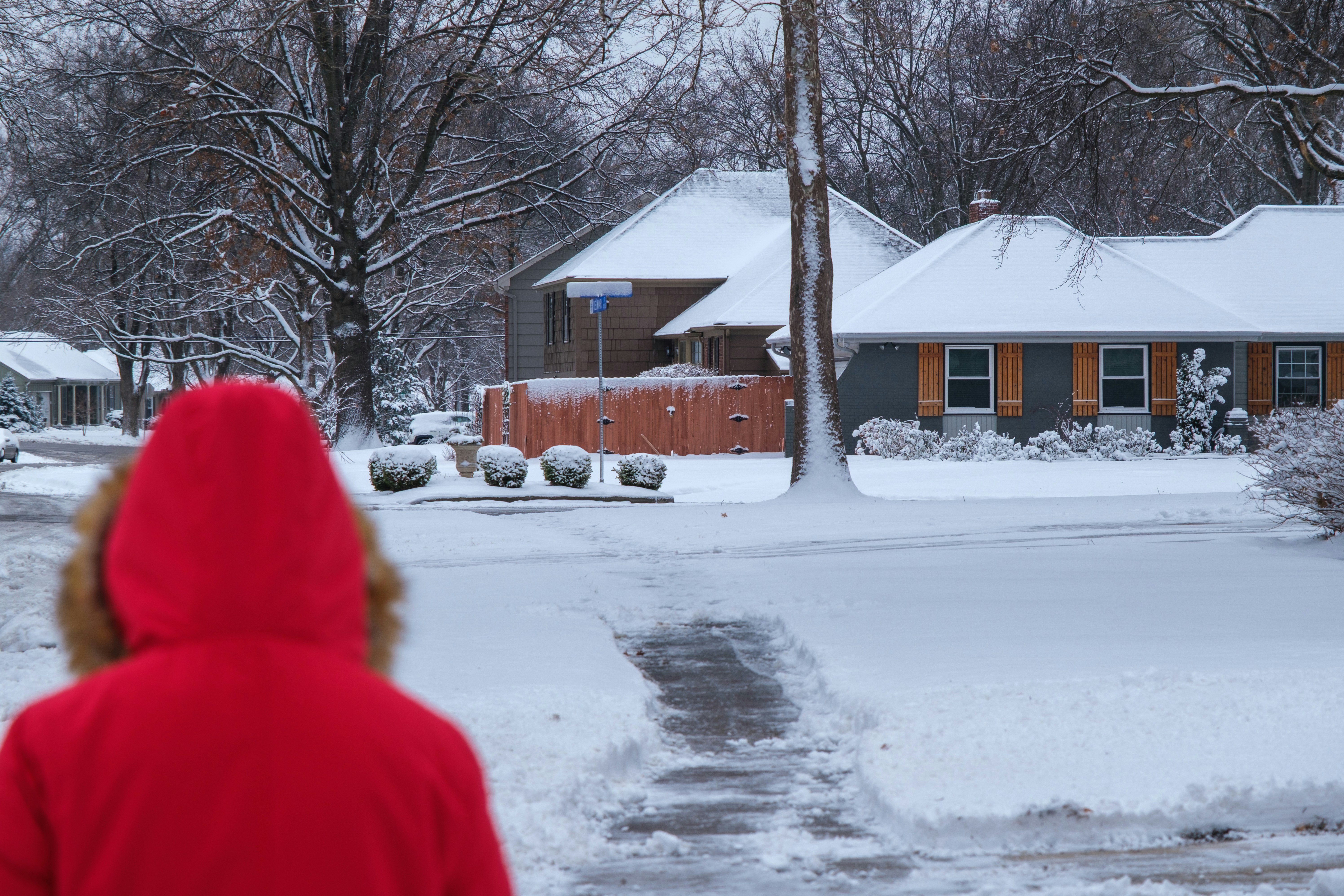 Red-Cloaked Figure Against a Quiet Snow-Covered Street