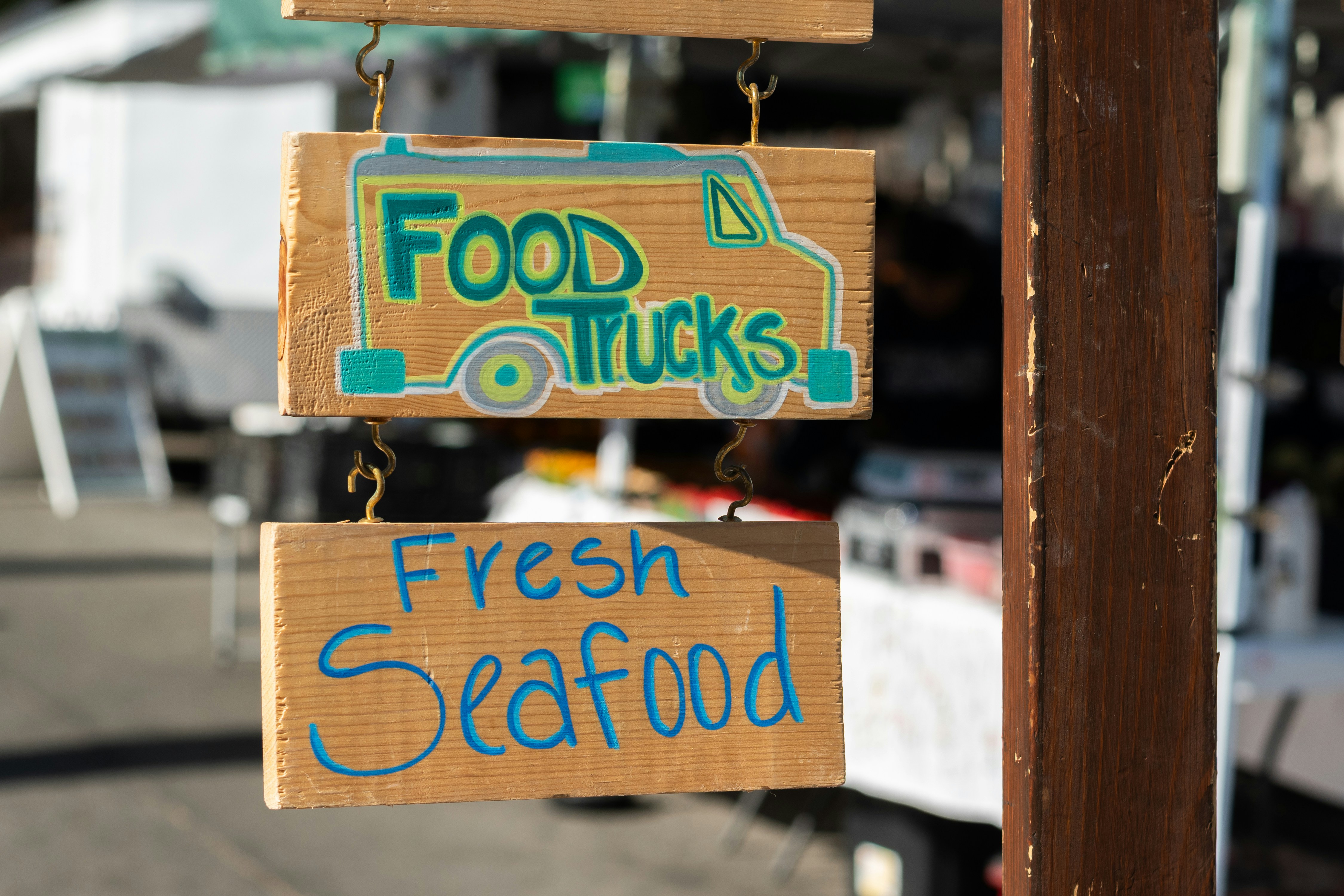 Handwritten Seafood Signage Over Wooden Boards at Market Entrance
