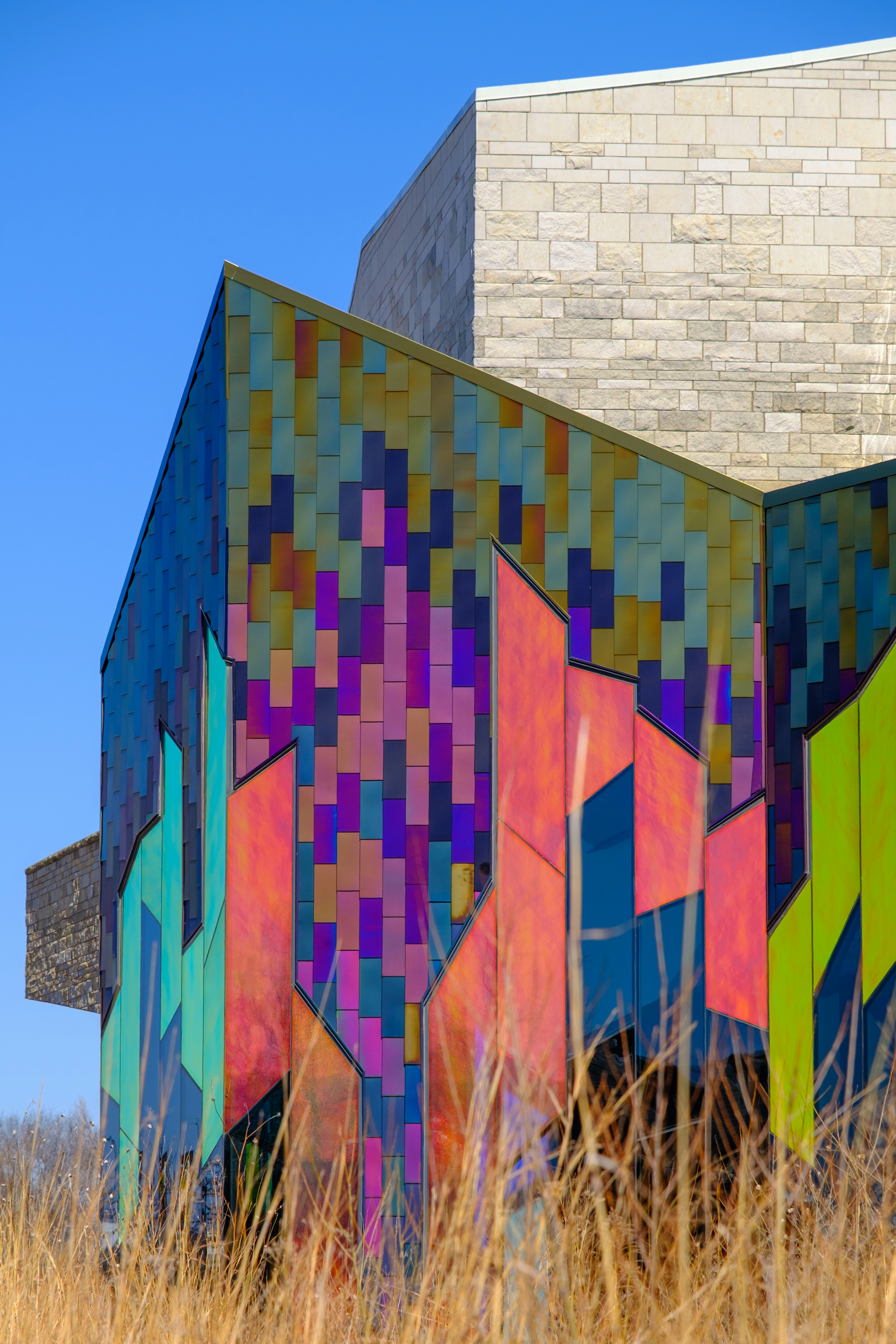 Kaleidoscopic Facade: Prism Wall Beside a Stone Structure