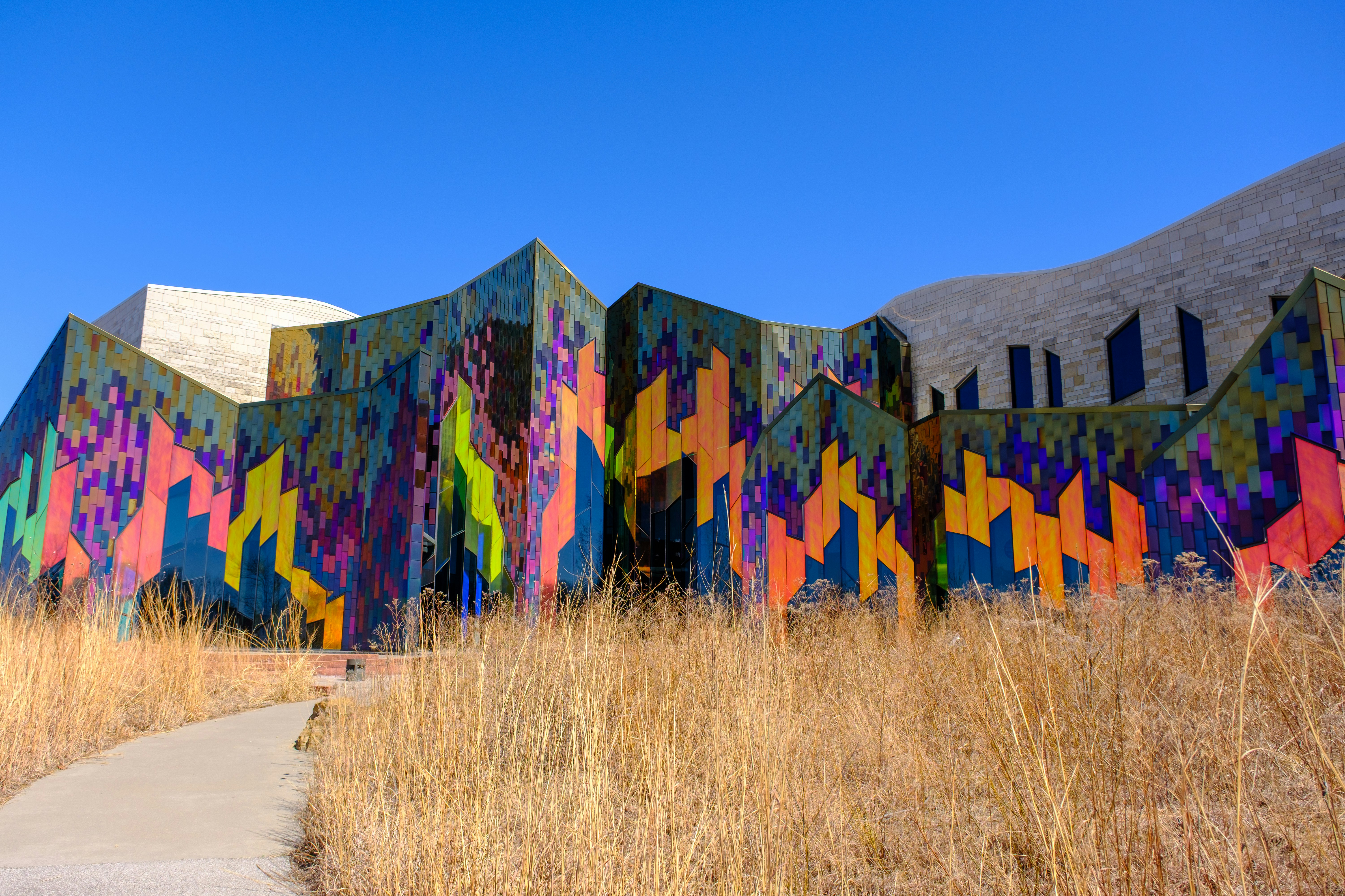 Kaleidoscopic Waves: A mural fortress rises over sunlit grasses