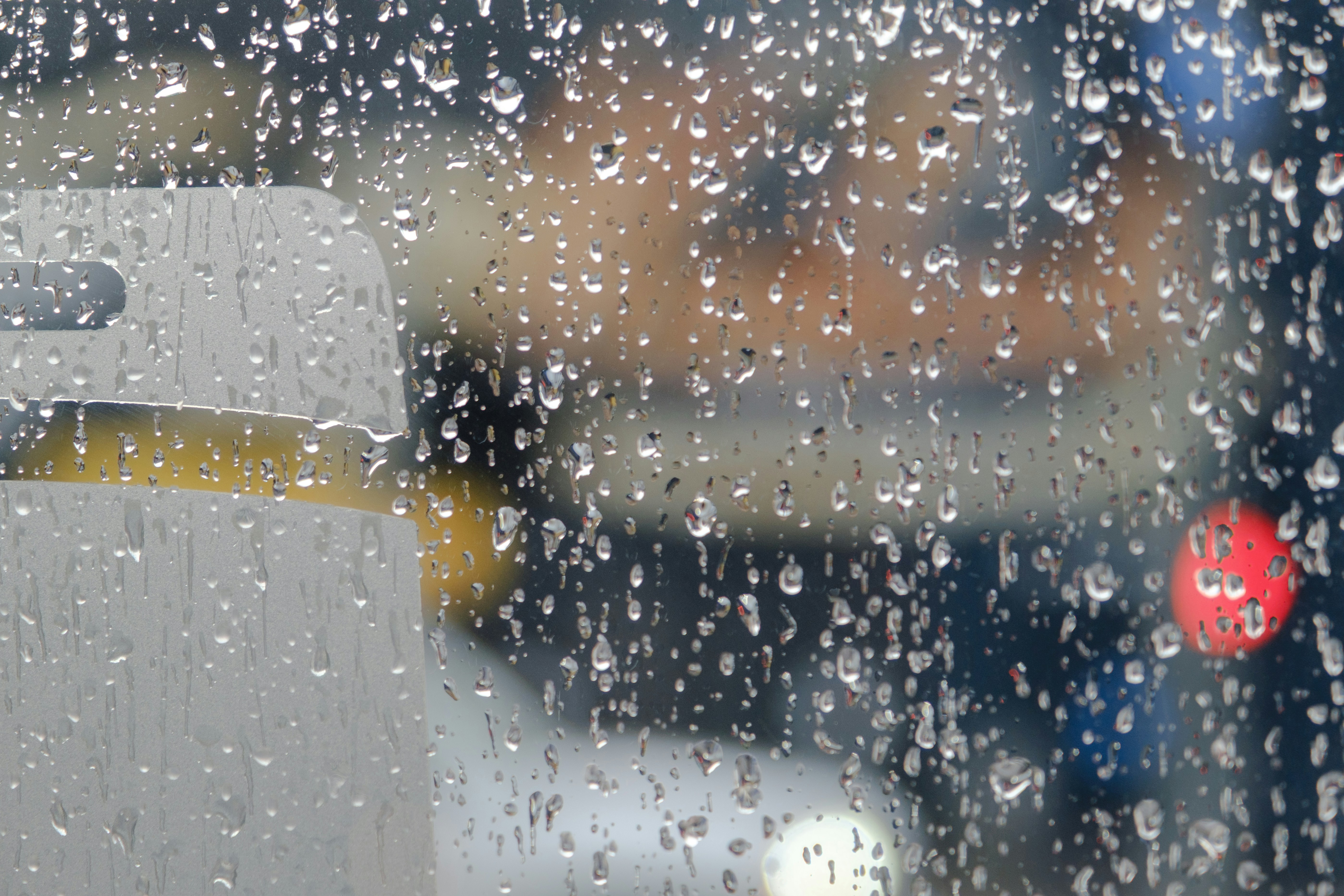 Raindrops on a Glass Barrier: Blur of City Lights Beyond