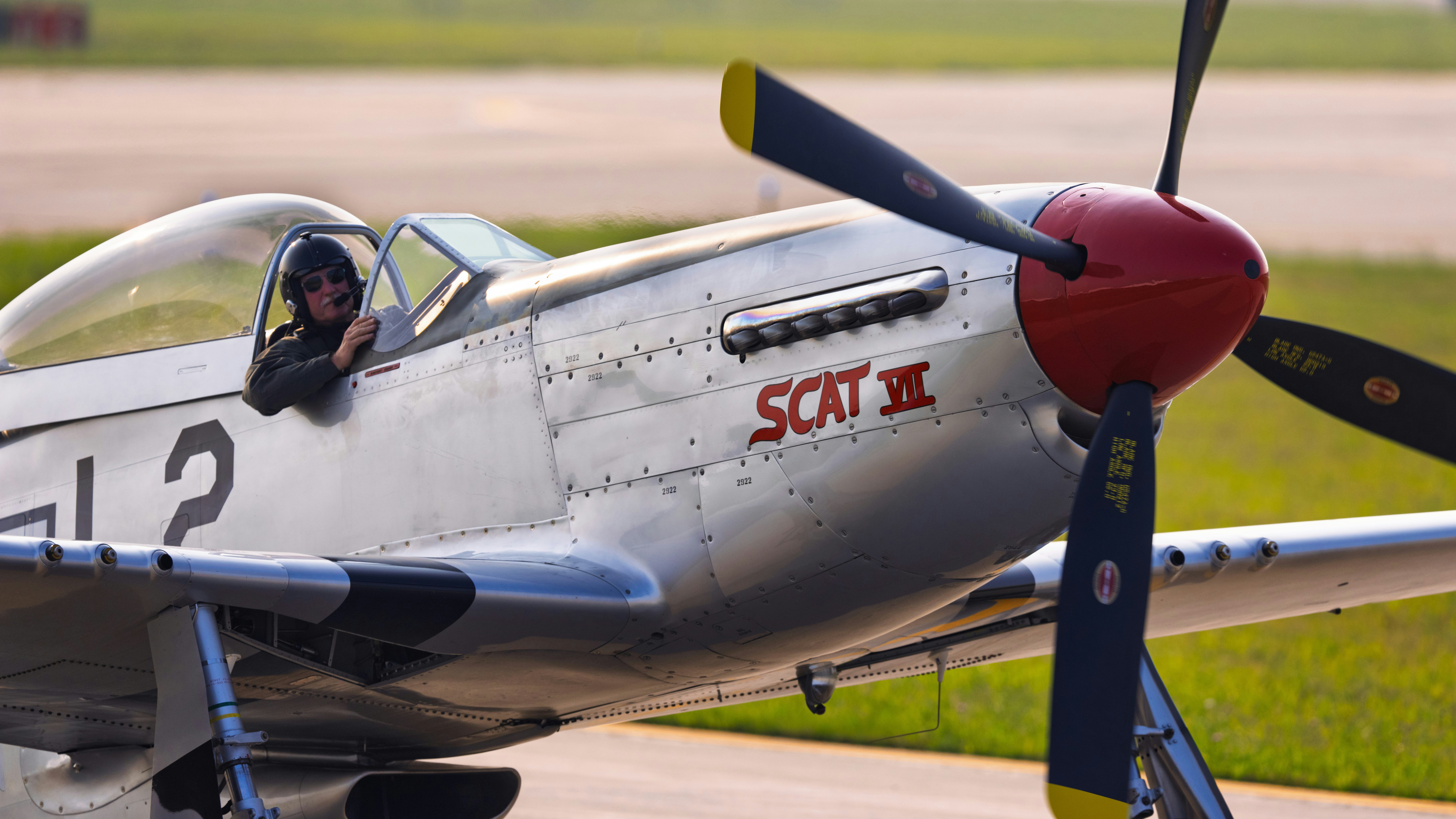 Vintage Propeller, Modern Focus: Pilot in the Cockpit by the Spinning Engine