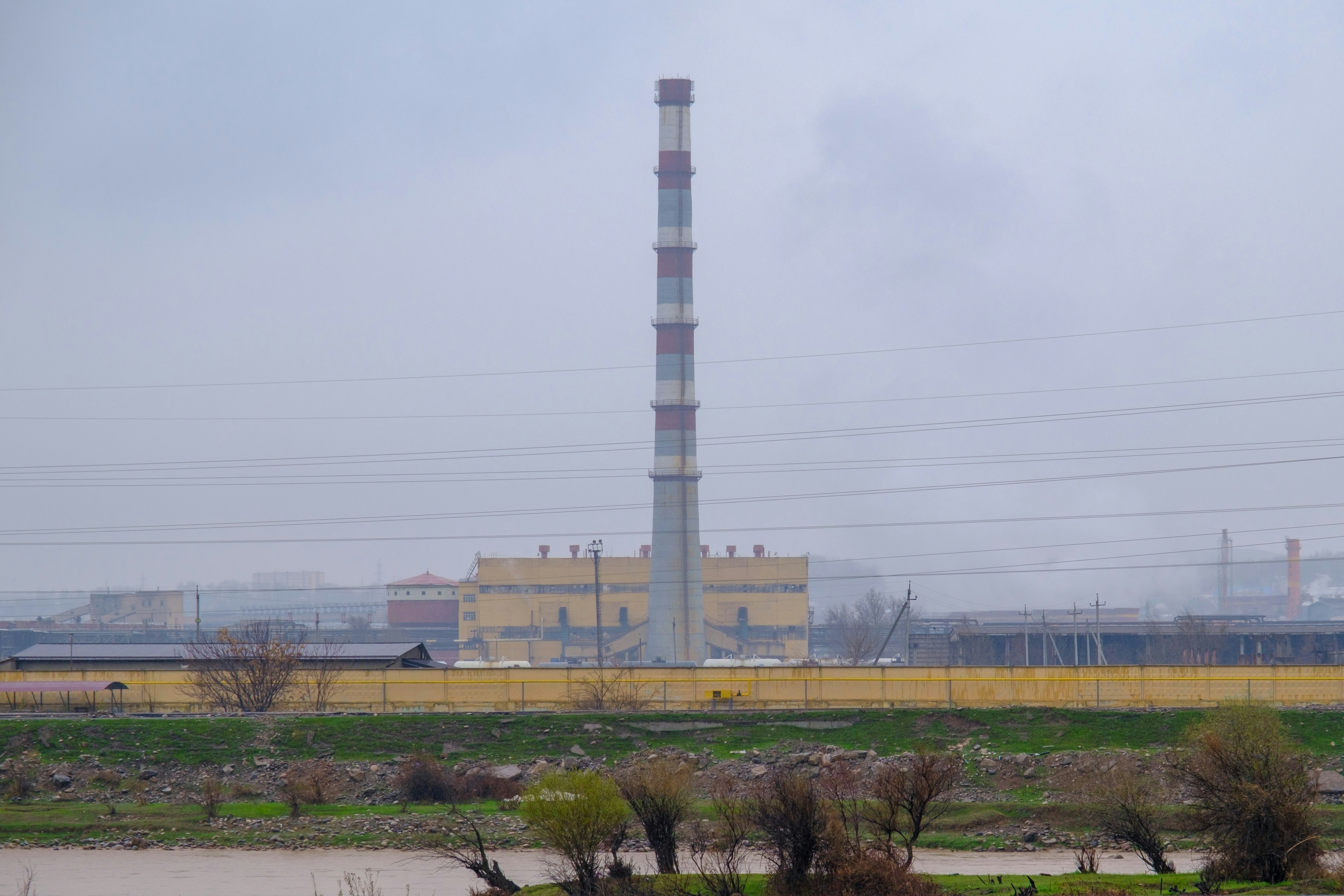 Chimney Sentinel Over a Quiet Industrial Plain