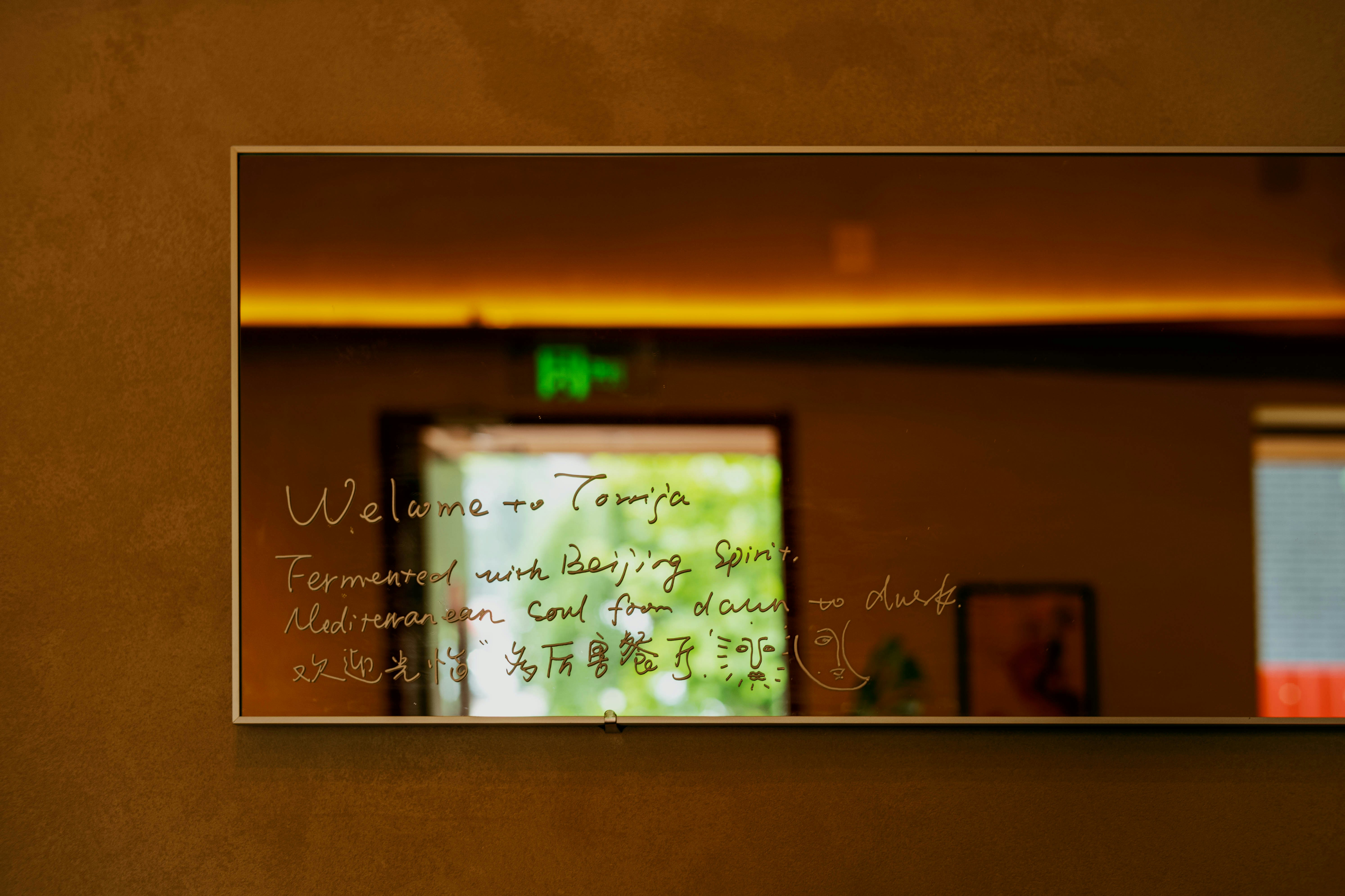 Mirror mural with handwritten script and neon glow in cozy gallery