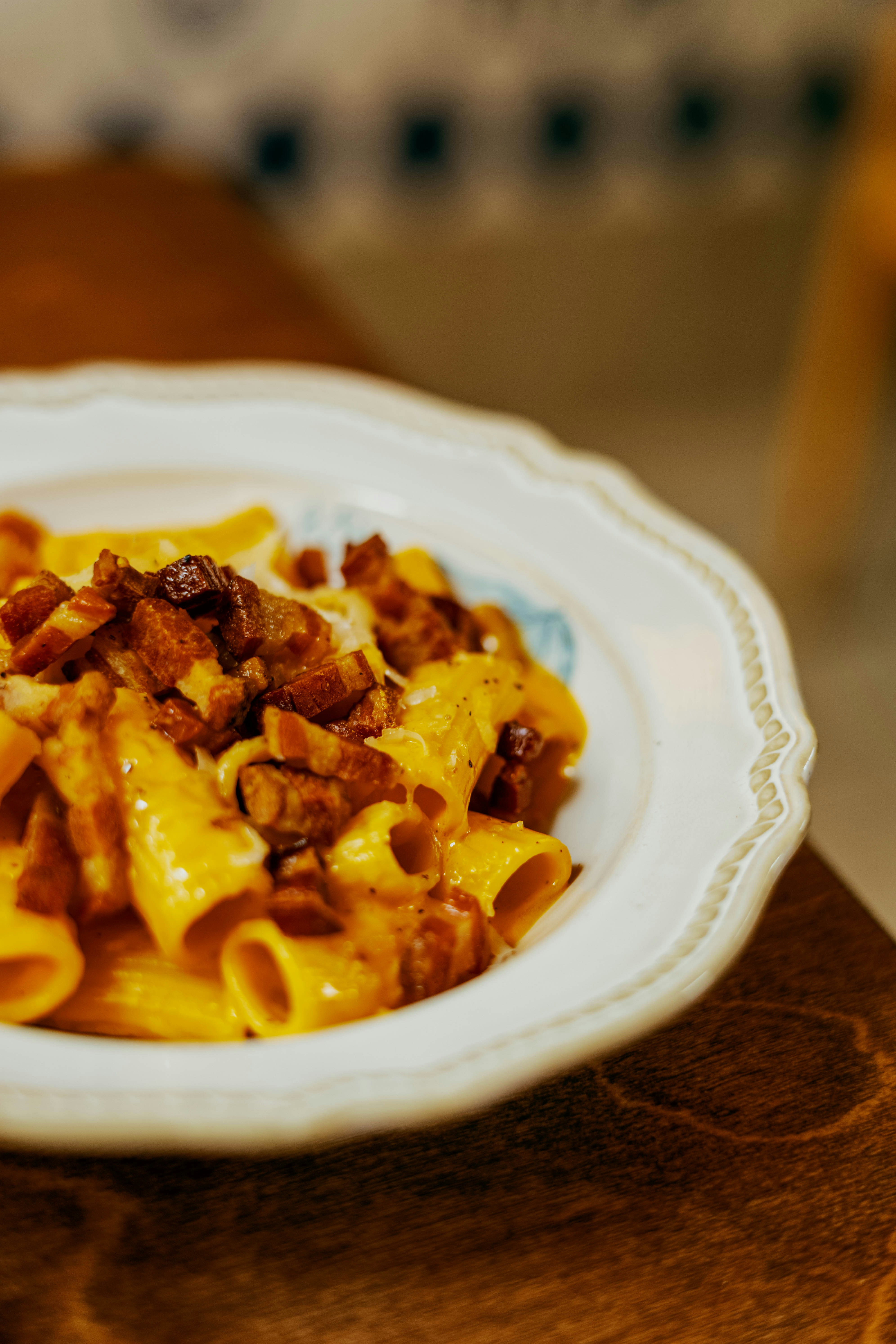 Creamy Penne in Caramelized Bacon Sauce on a Curved White Plate