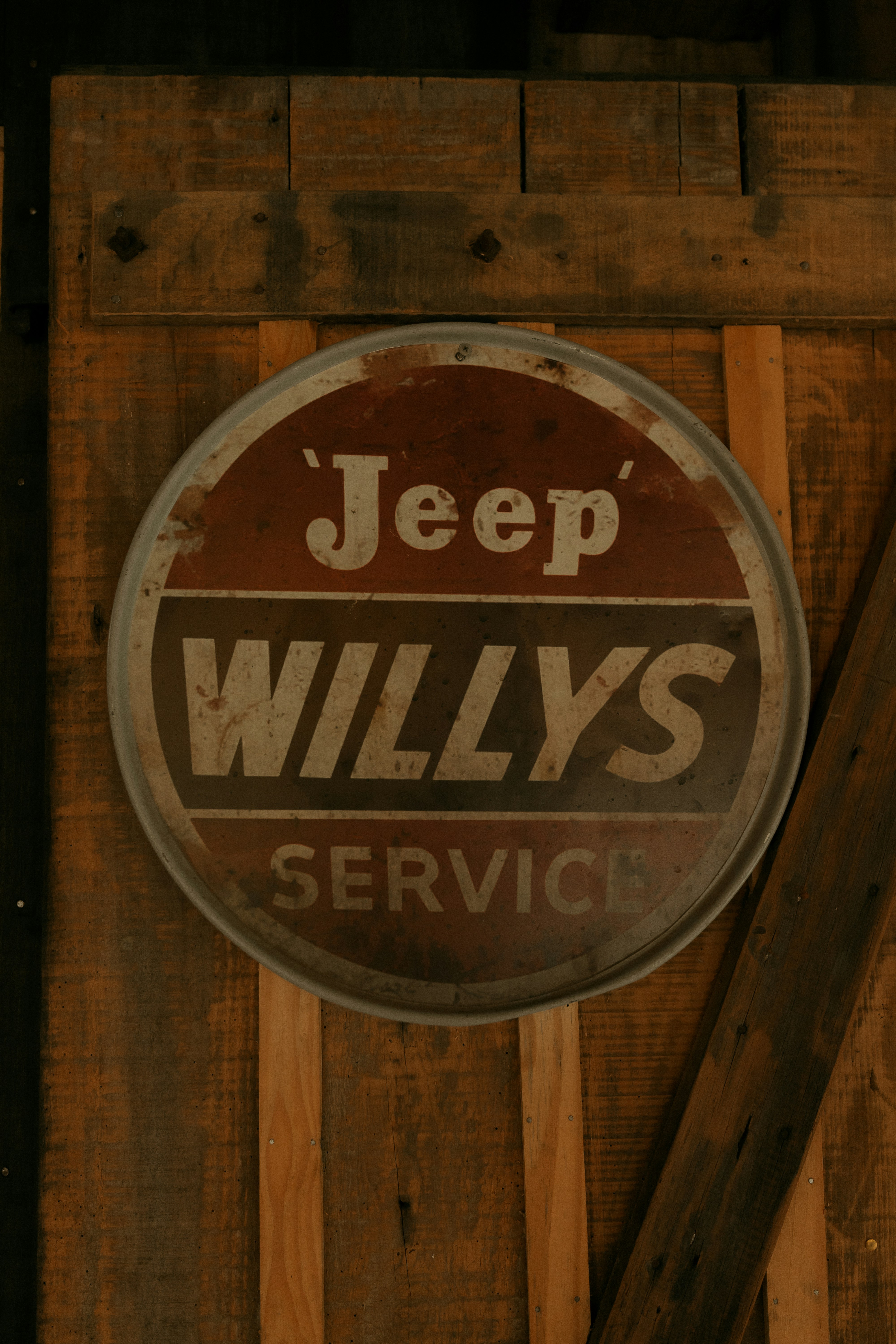 Weathered Jeep Willys emblem in warm-toned barn wood