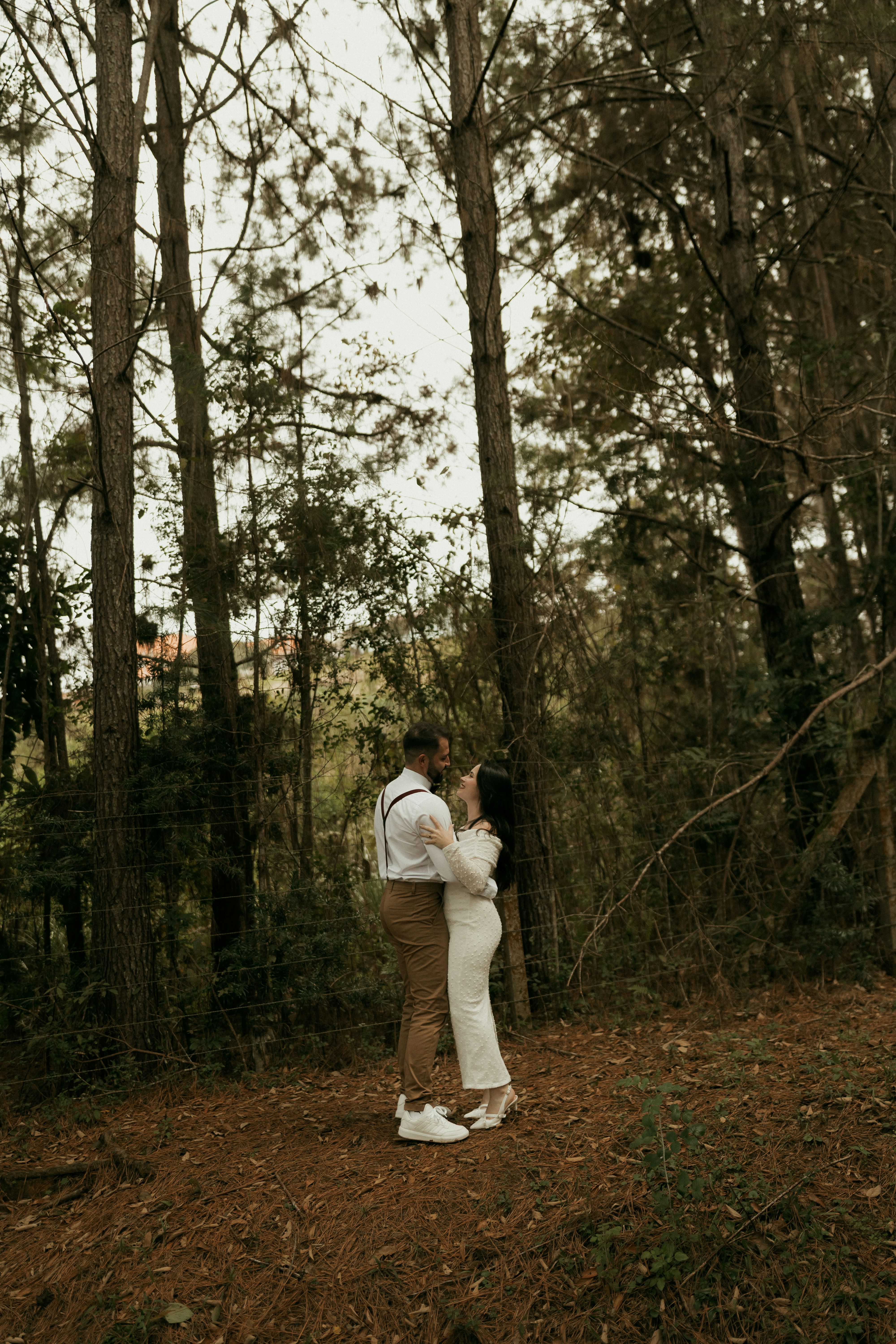 Whispered vows in the woods: a couple embraces under autumn trees