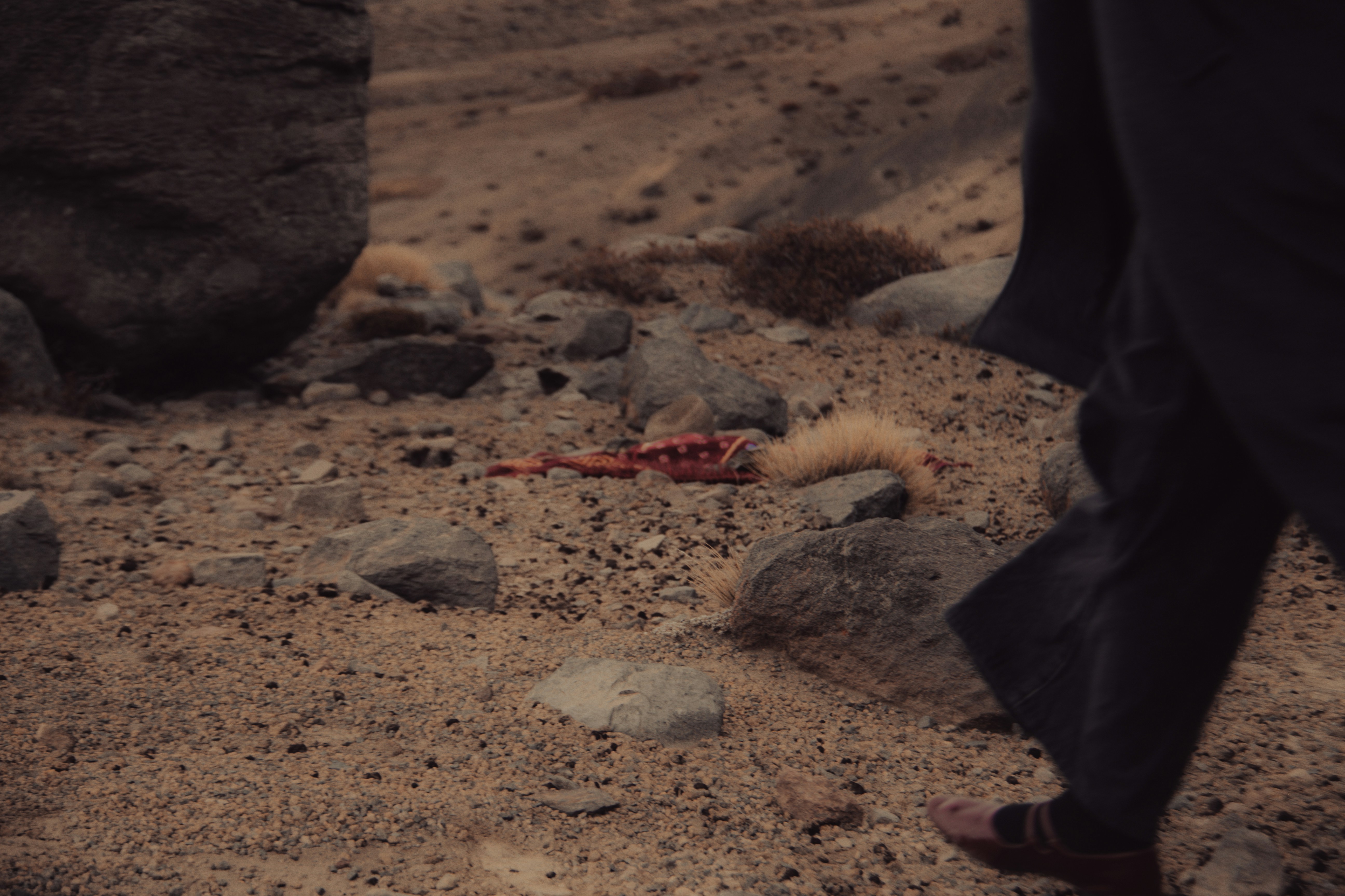 Deserted Footsteps: A Lone Voyager Crossing a Stony Dune