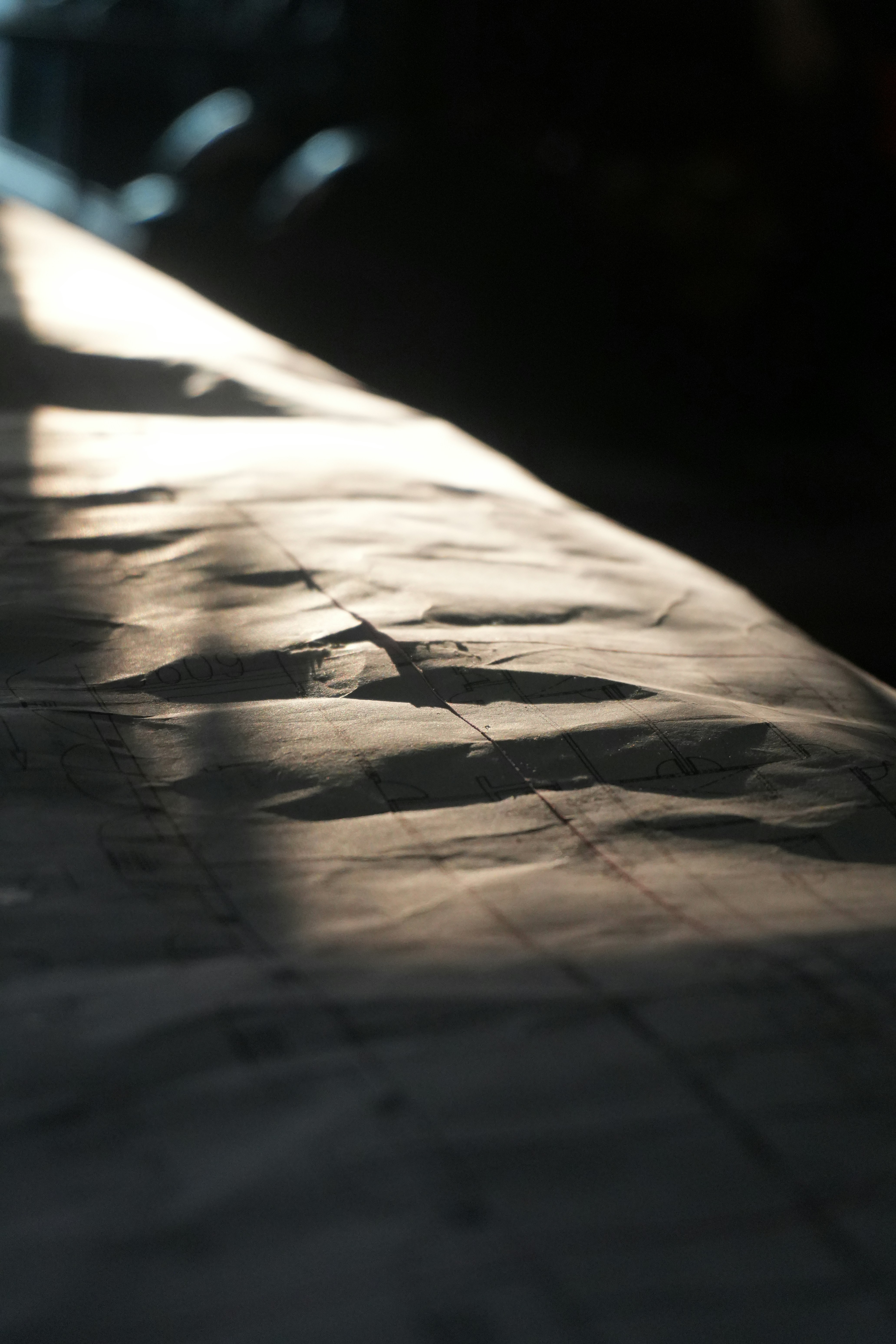 Sunlit Crumple: A Quiet Beam Across Weathered Paper