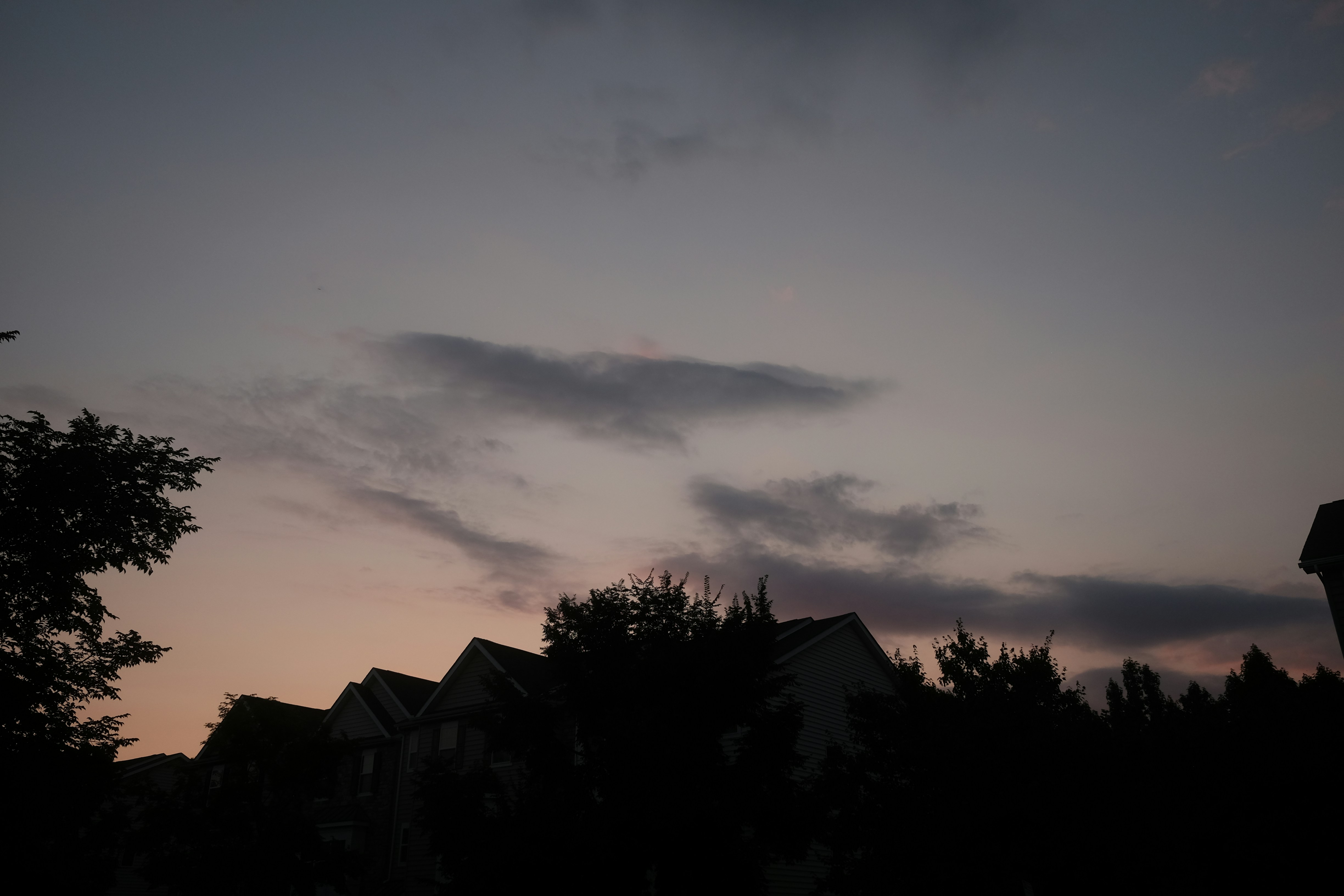 Dusk Silhouettes: Suburban Roofline Against Soft Evening Sky