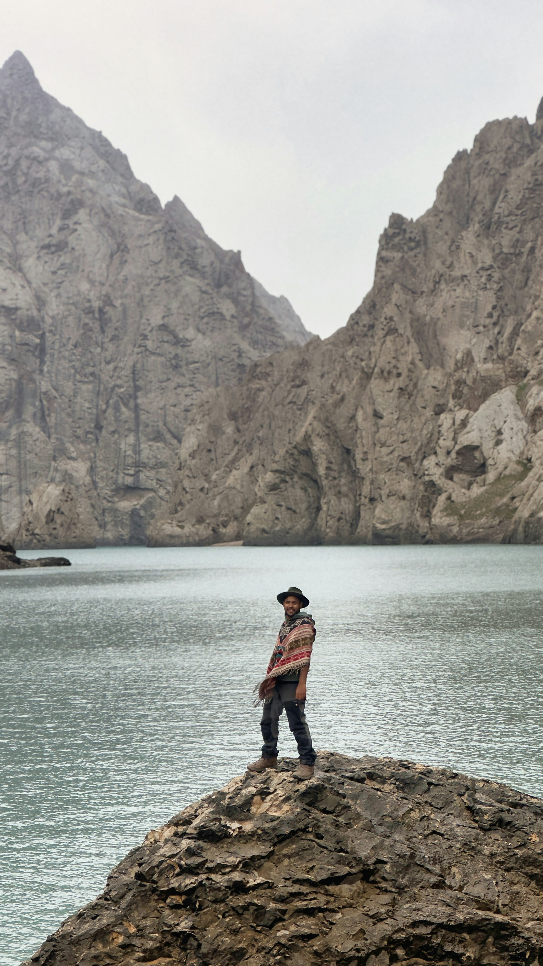 Wanderer at the Edge: Lone Figure on a Rocky Promontory