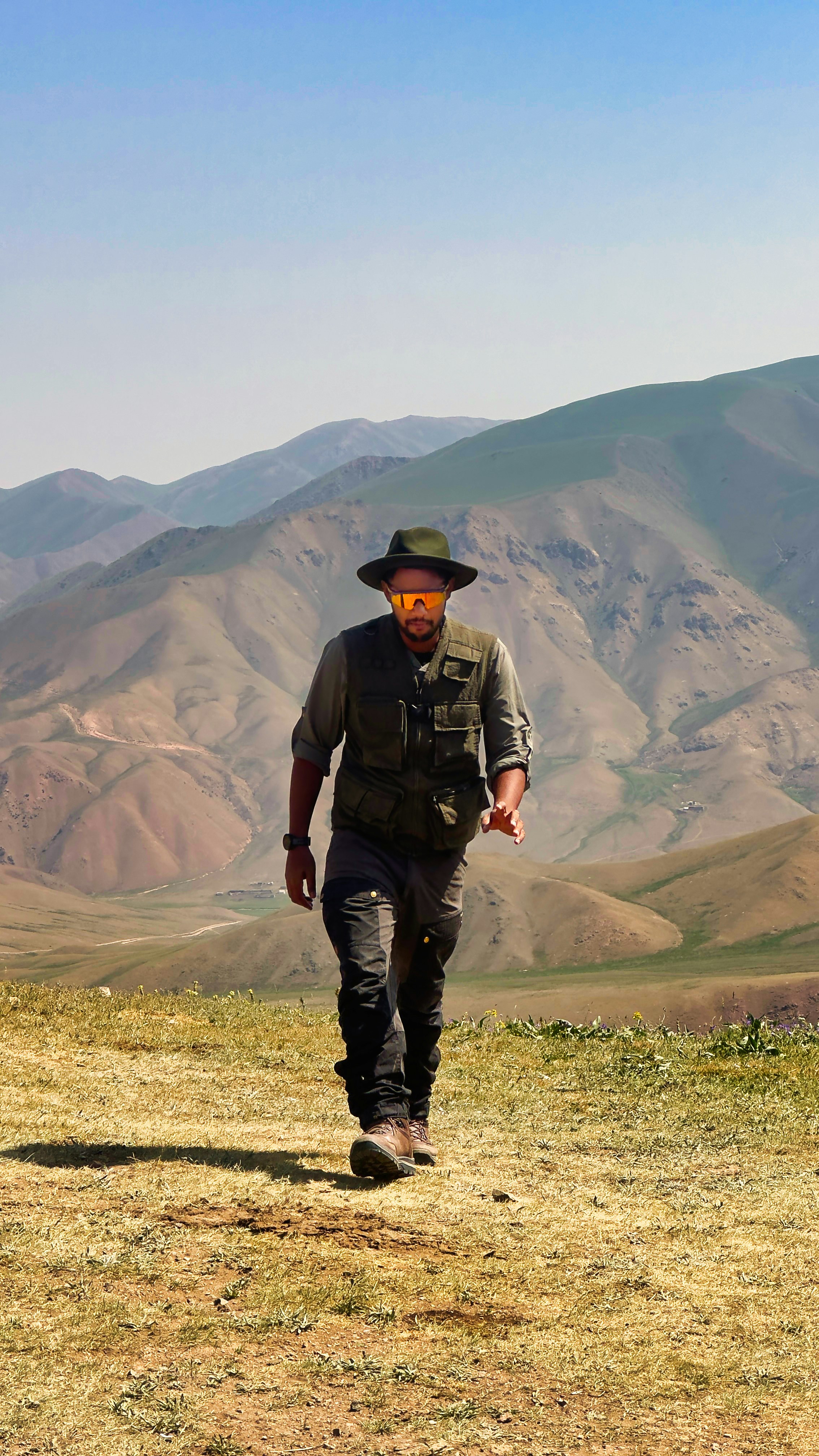 Trailbound: a lone explorer advances through sunlit hills