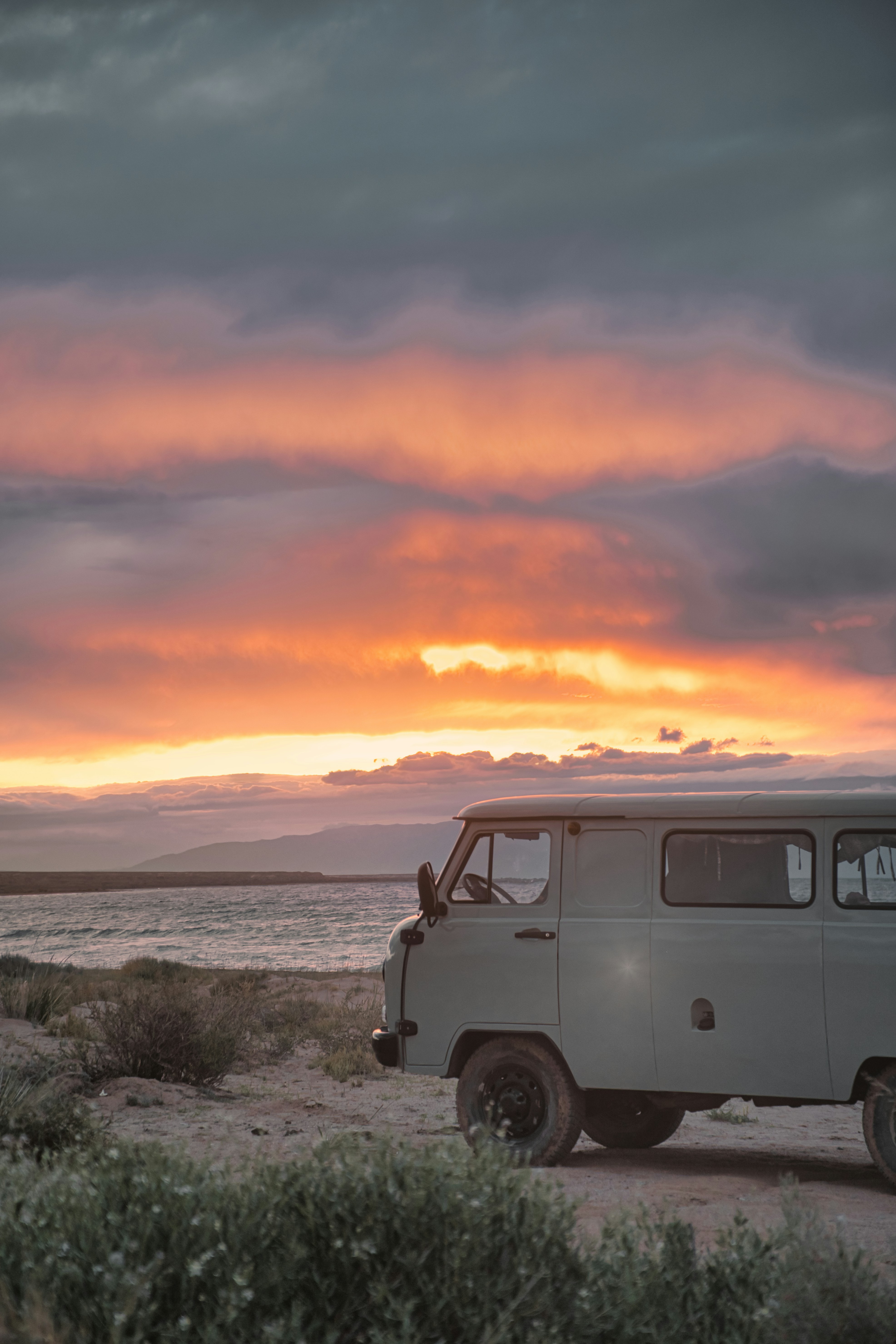 Sunset Roadside: A Weathered Van Watches the Sea