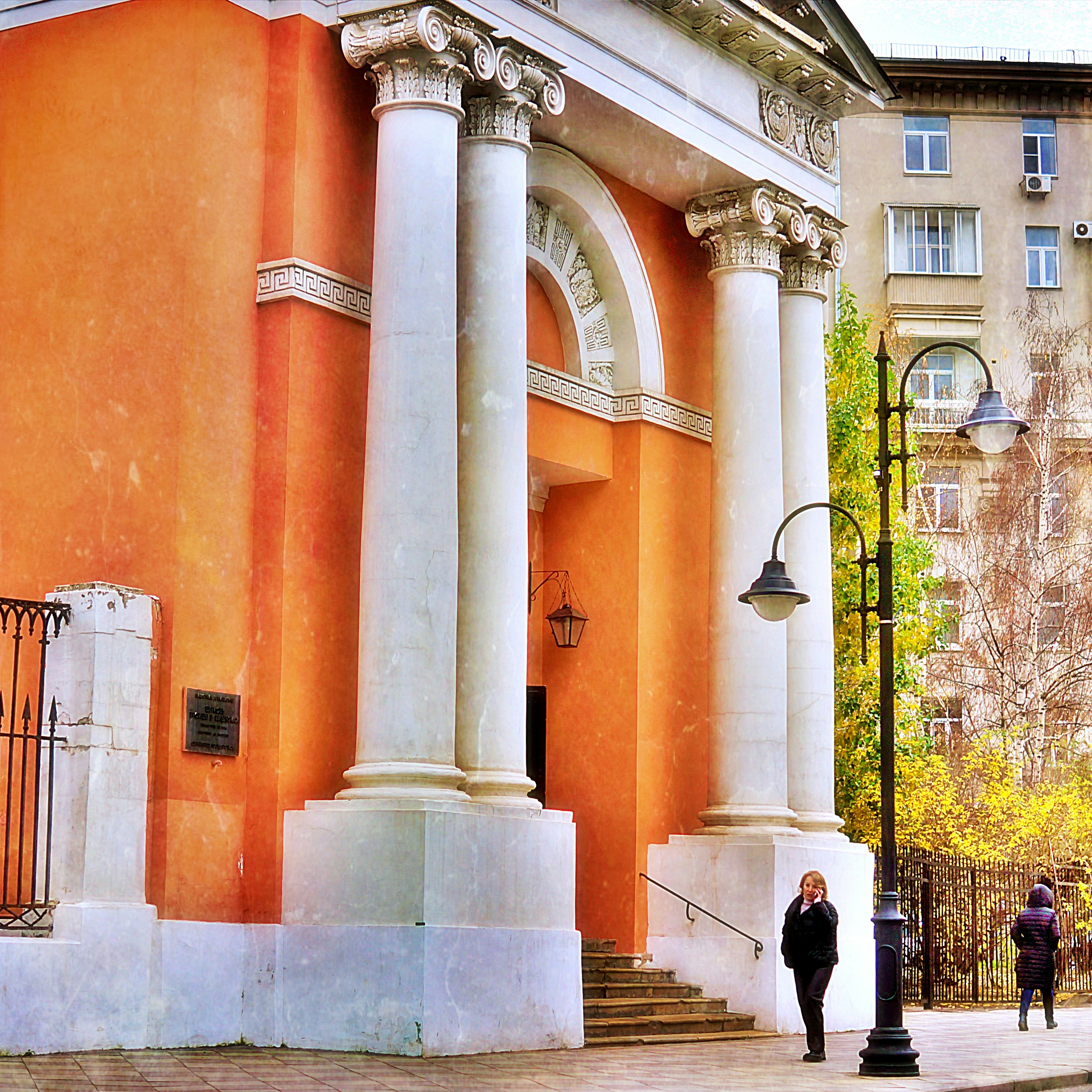 Orange-Porticoed Entrance framed by Columns and a Quiet Street Scene