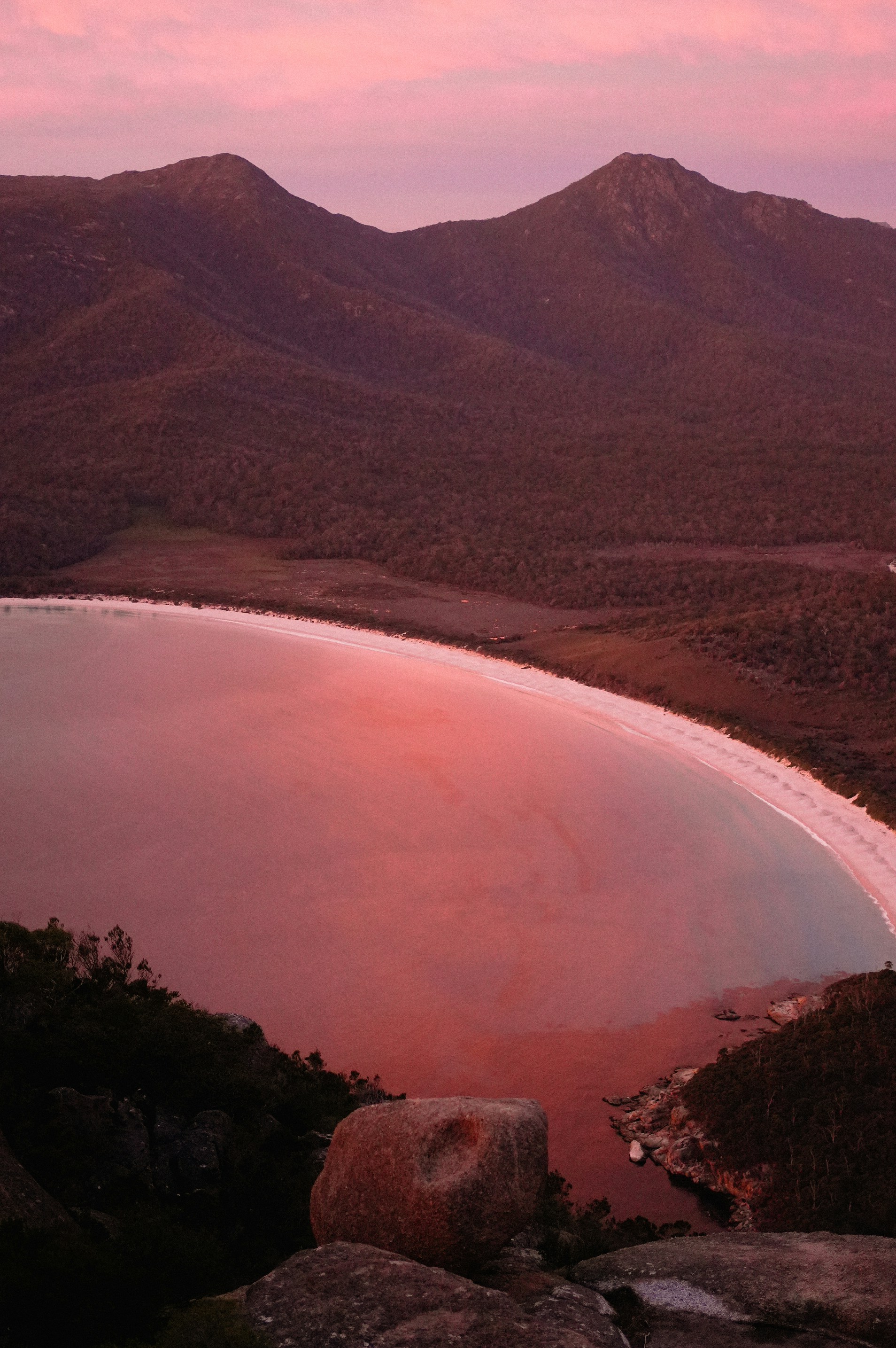 Pink-hued Crescent: A Secluded Coastal Ridge at Dusk