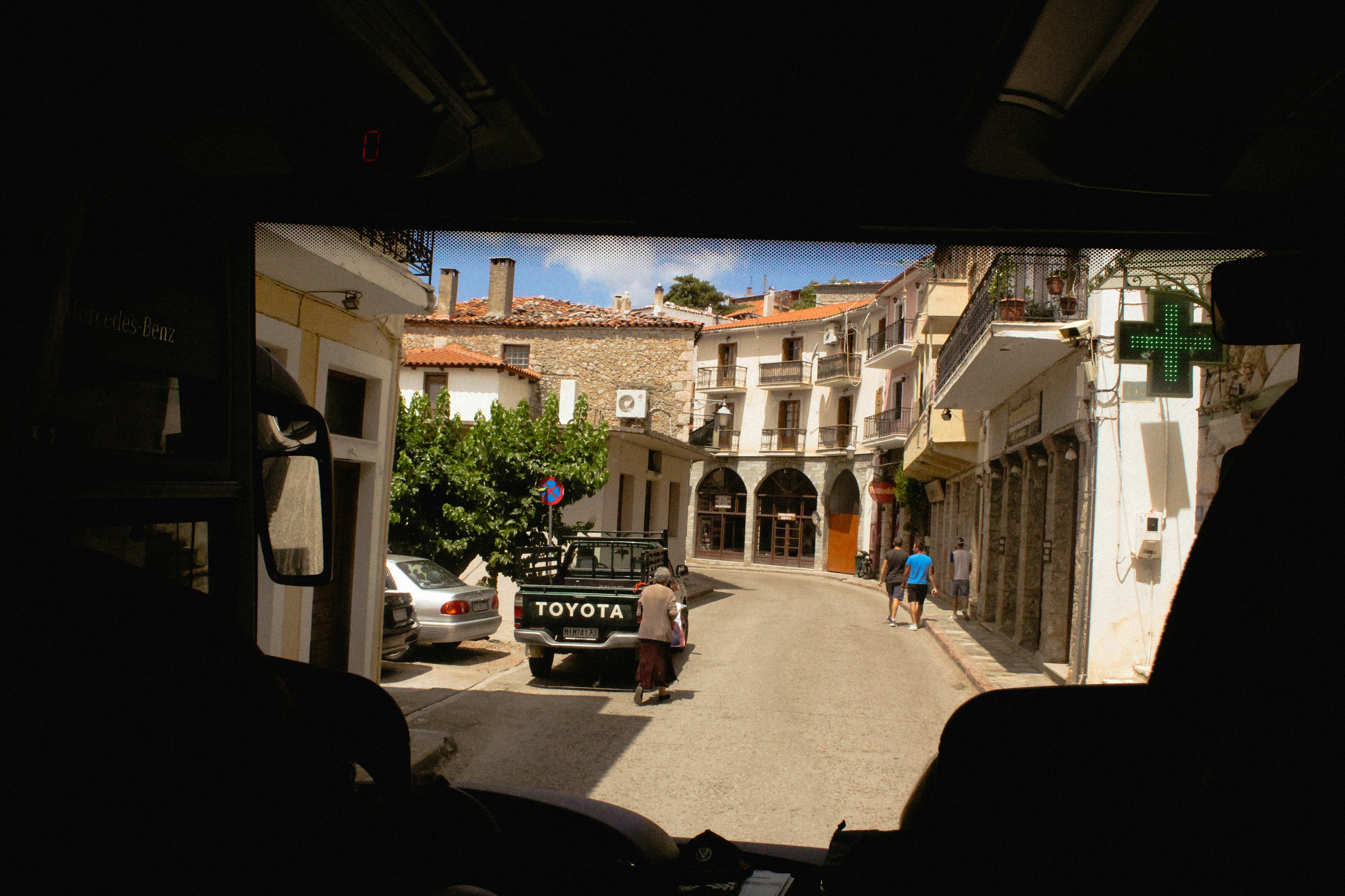 A Sunlit Town Corridor Framed by Vehicle Window