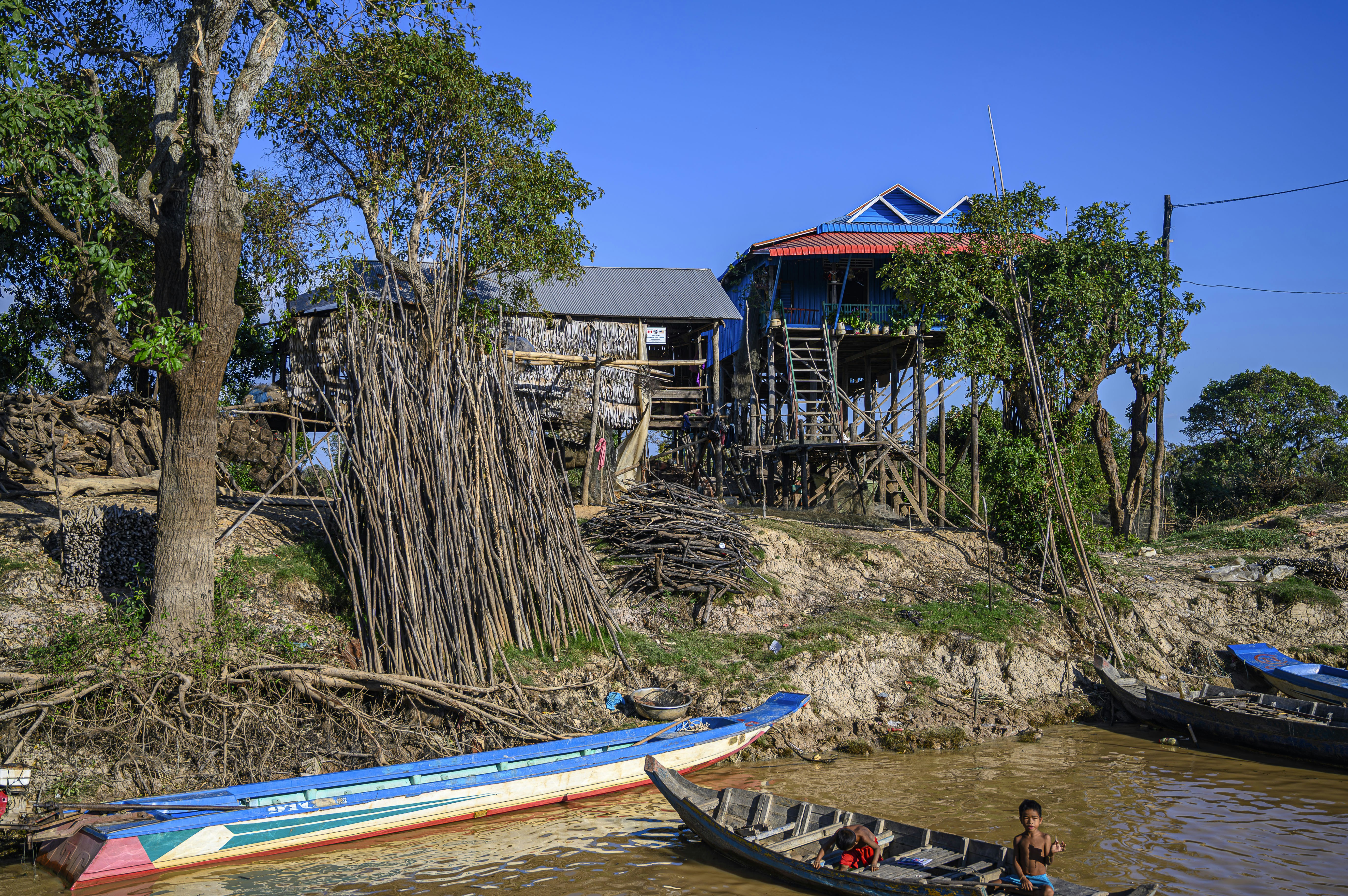 Riverside Stilt Village with Colorful Boats at Dappled Light