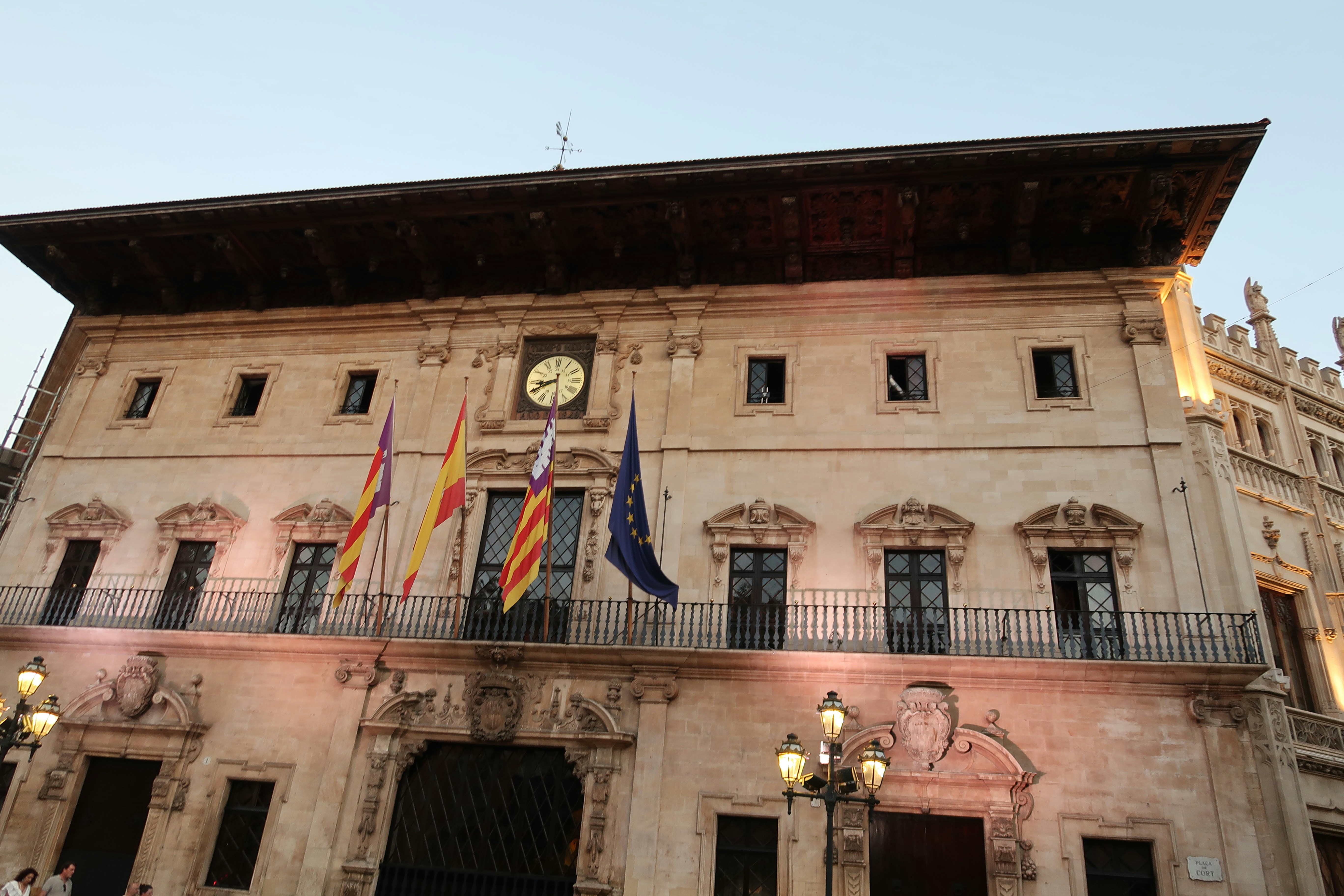 Facade of a Historic Building with Flags at Dawn