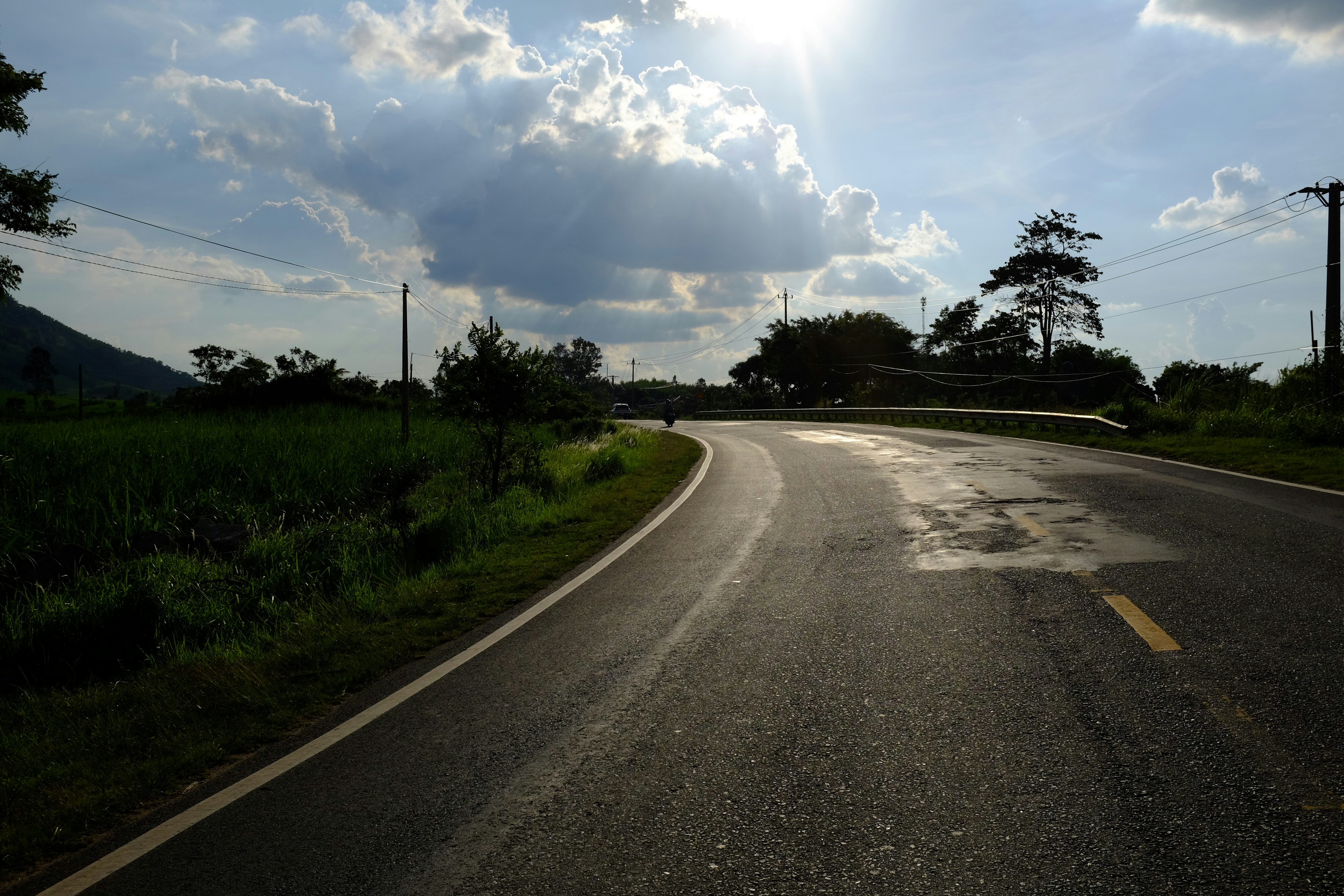 A Sunlit Curve: Quiet Rural Road Bends Toward Distant Hills