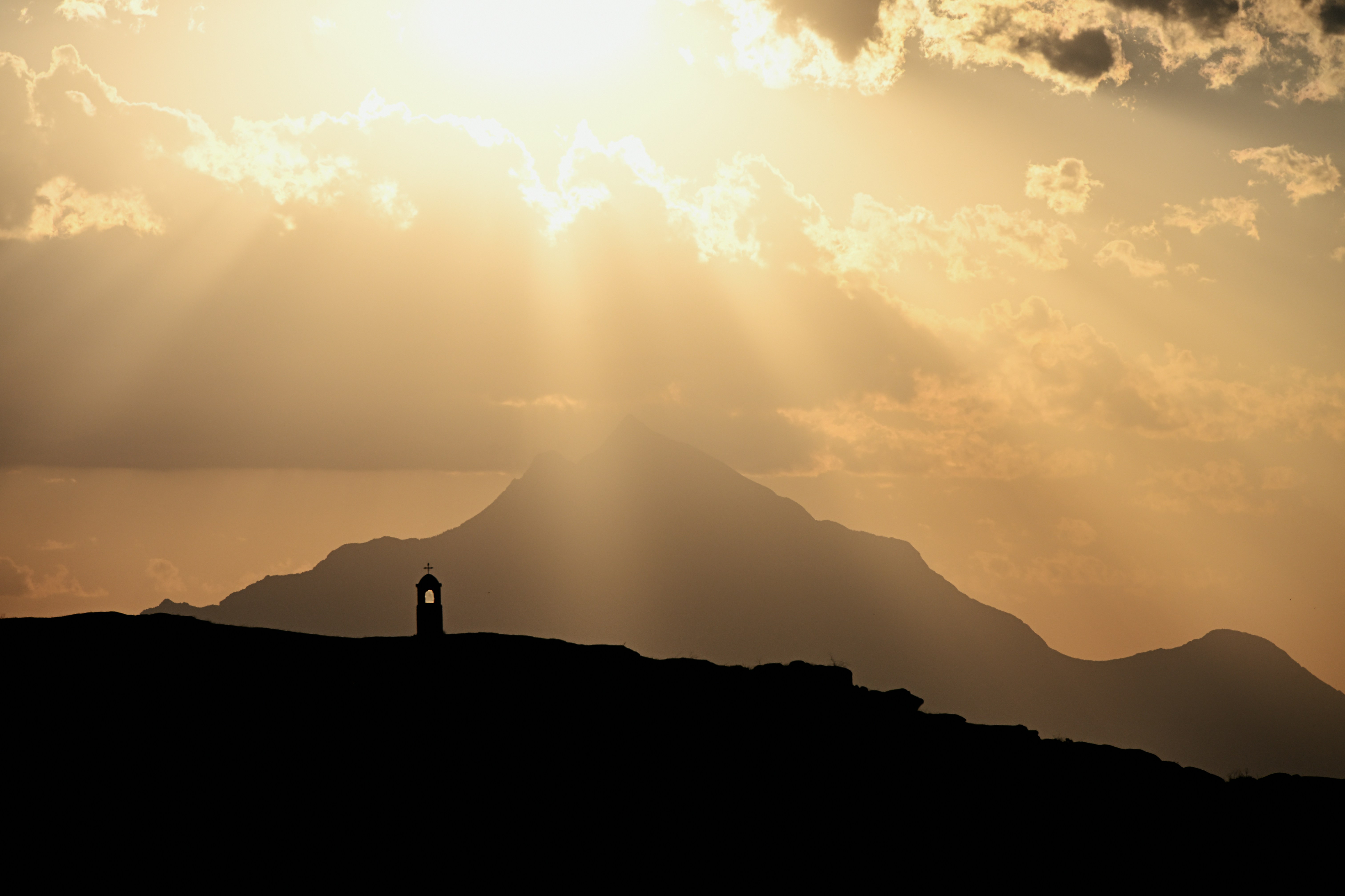 Dawn at the Lighthouse: Silhouette of a Sentinel against a Golden Ridge