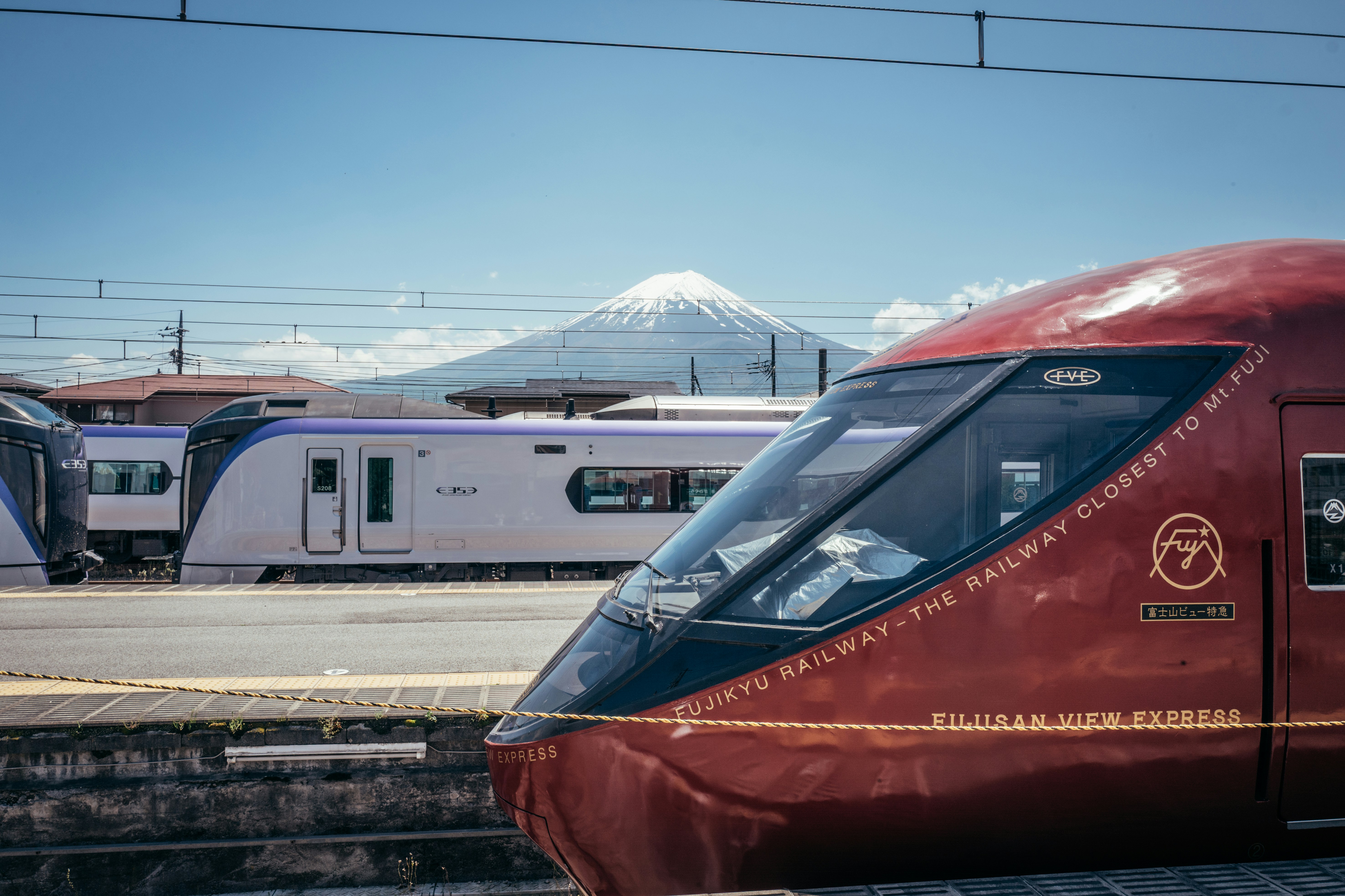 Front-Corner Viaduct: A Red Train Framing the Distant Snow-Capped Peak