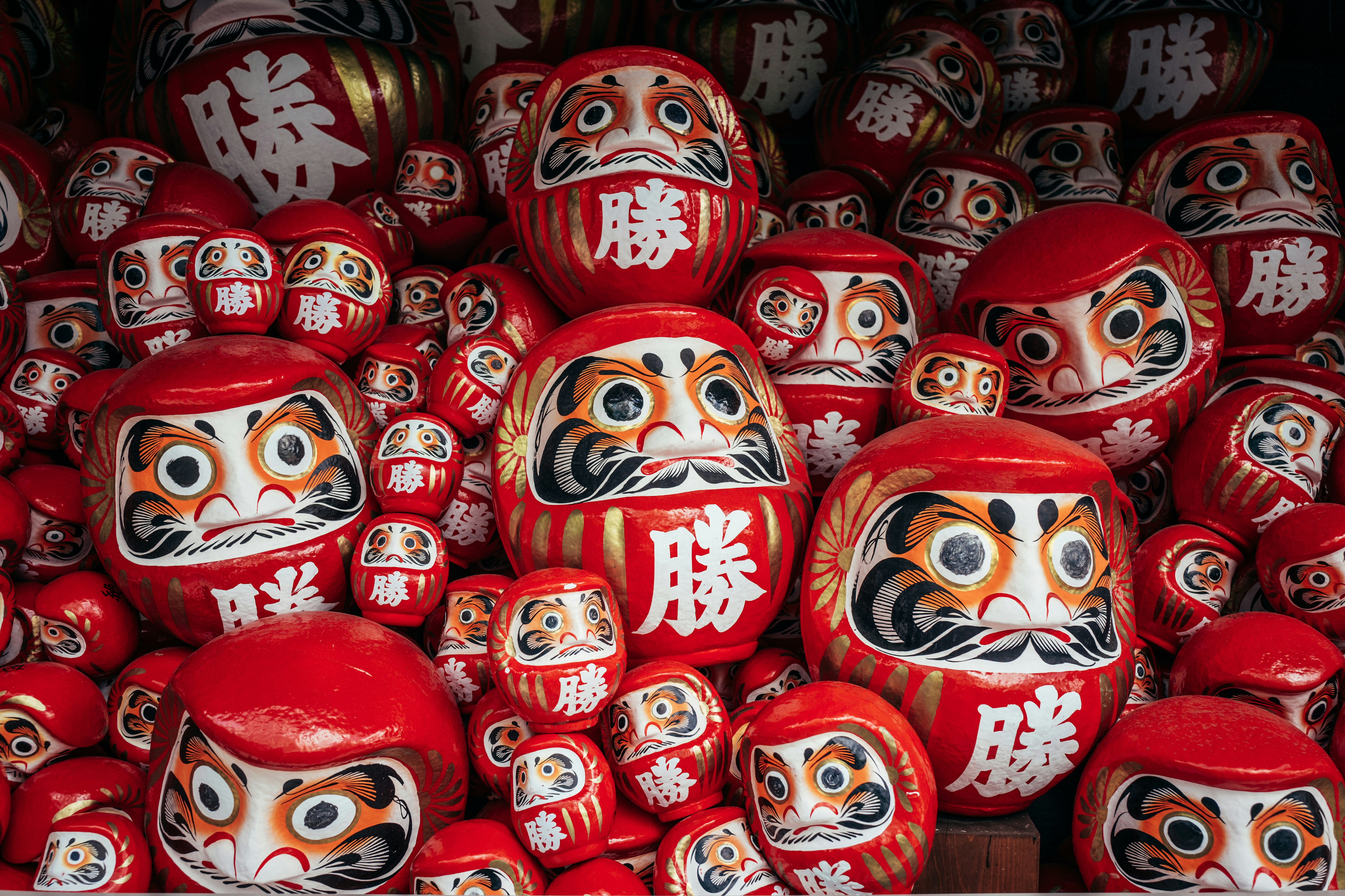 Red Wave: Matryoshka Faces in a Sea of Daruma