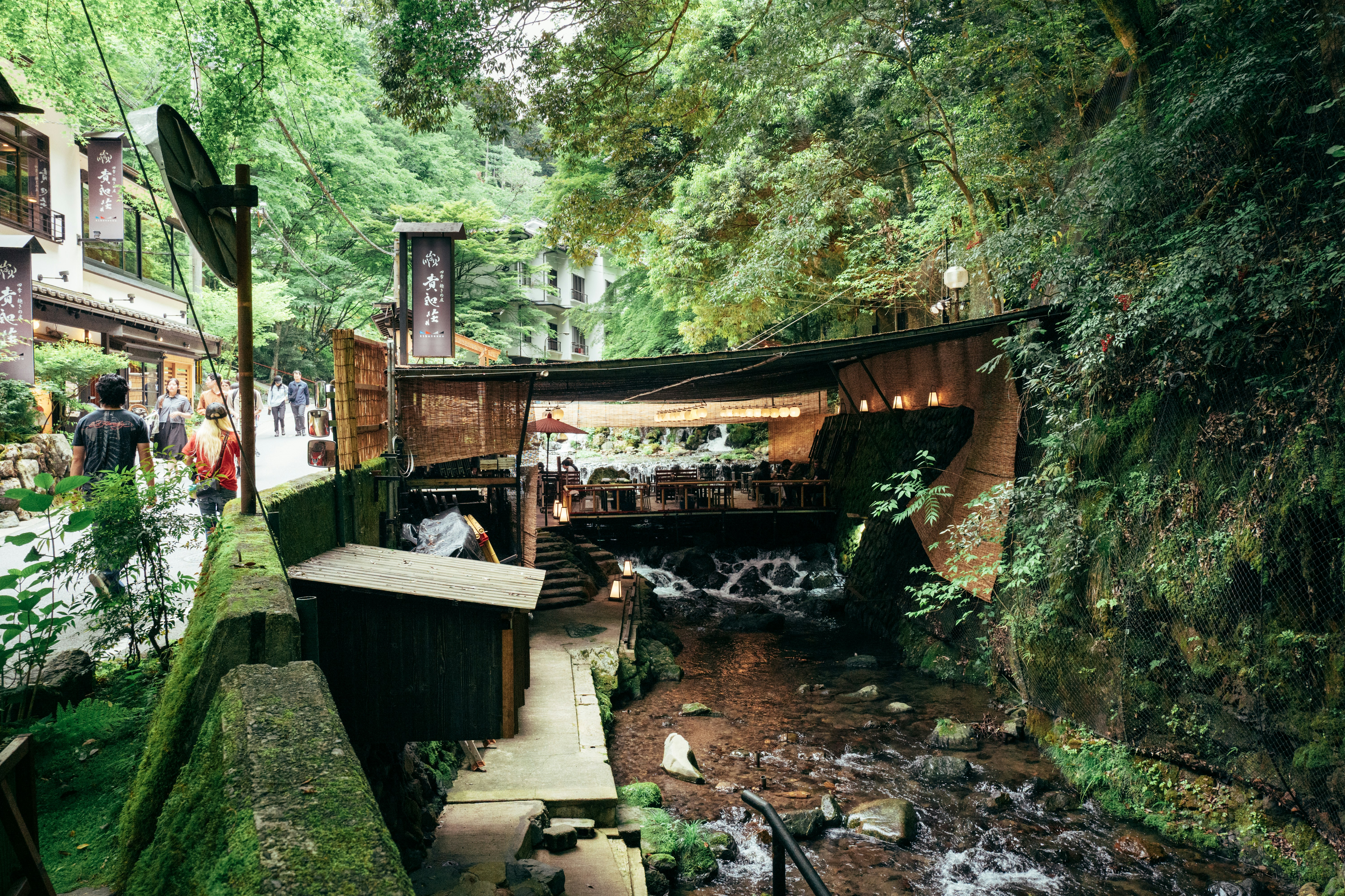 Shaded canal crossing a lively hillside street