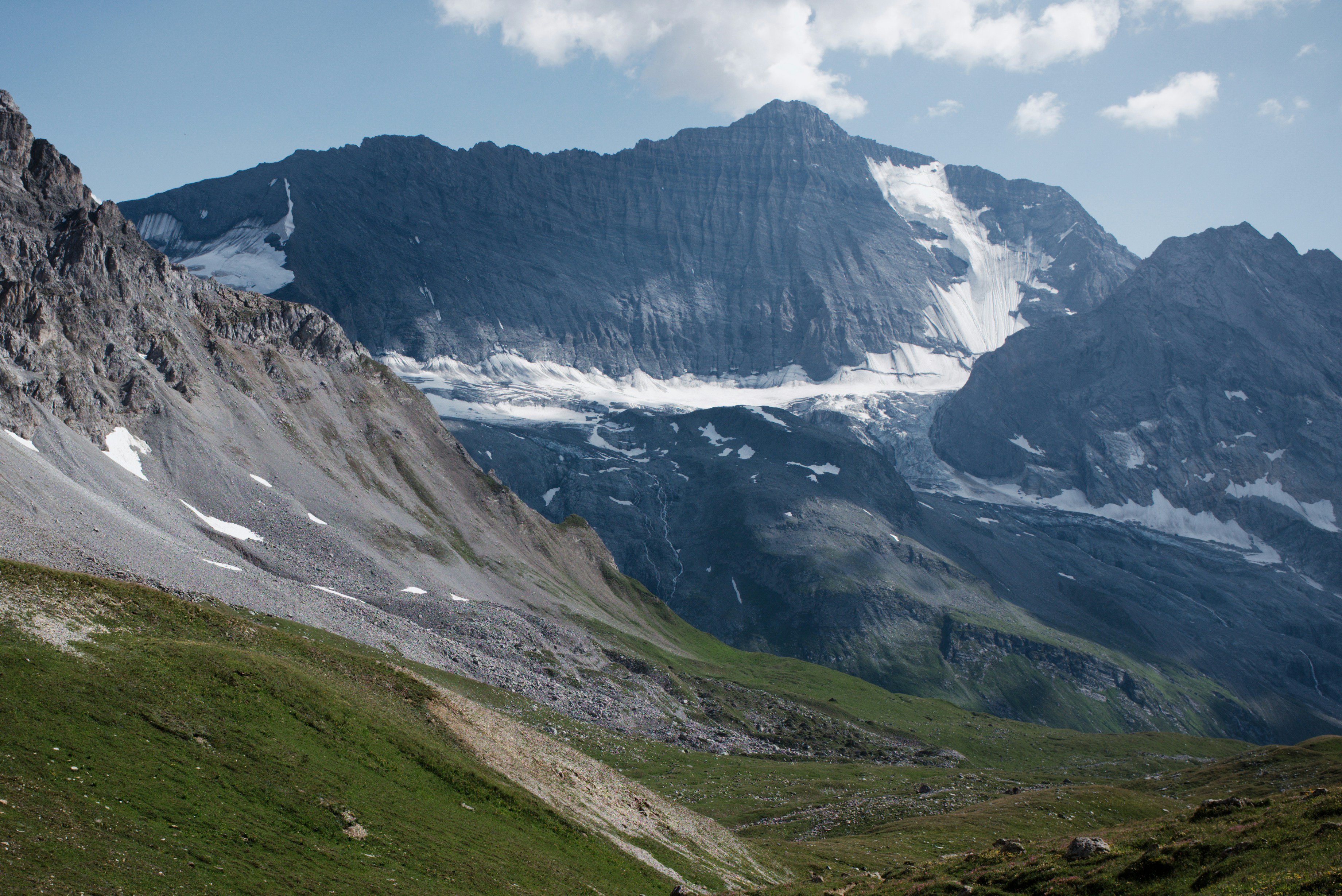 Snowbound Summit: A Mountain Pass Opens to Green Velvety Slopes