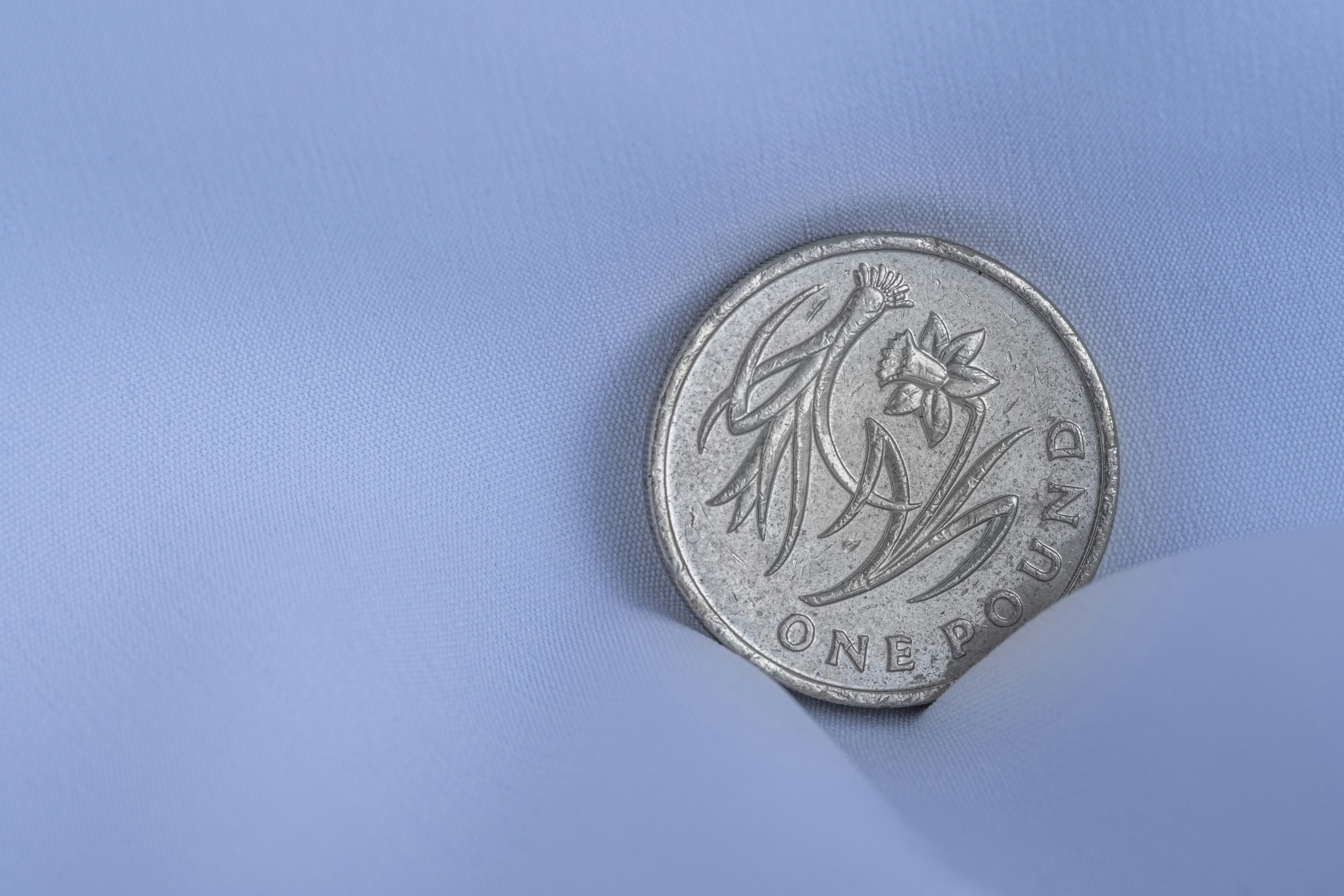 Coin Nestle: A Lone One Pence Beside Soft Blue Fold