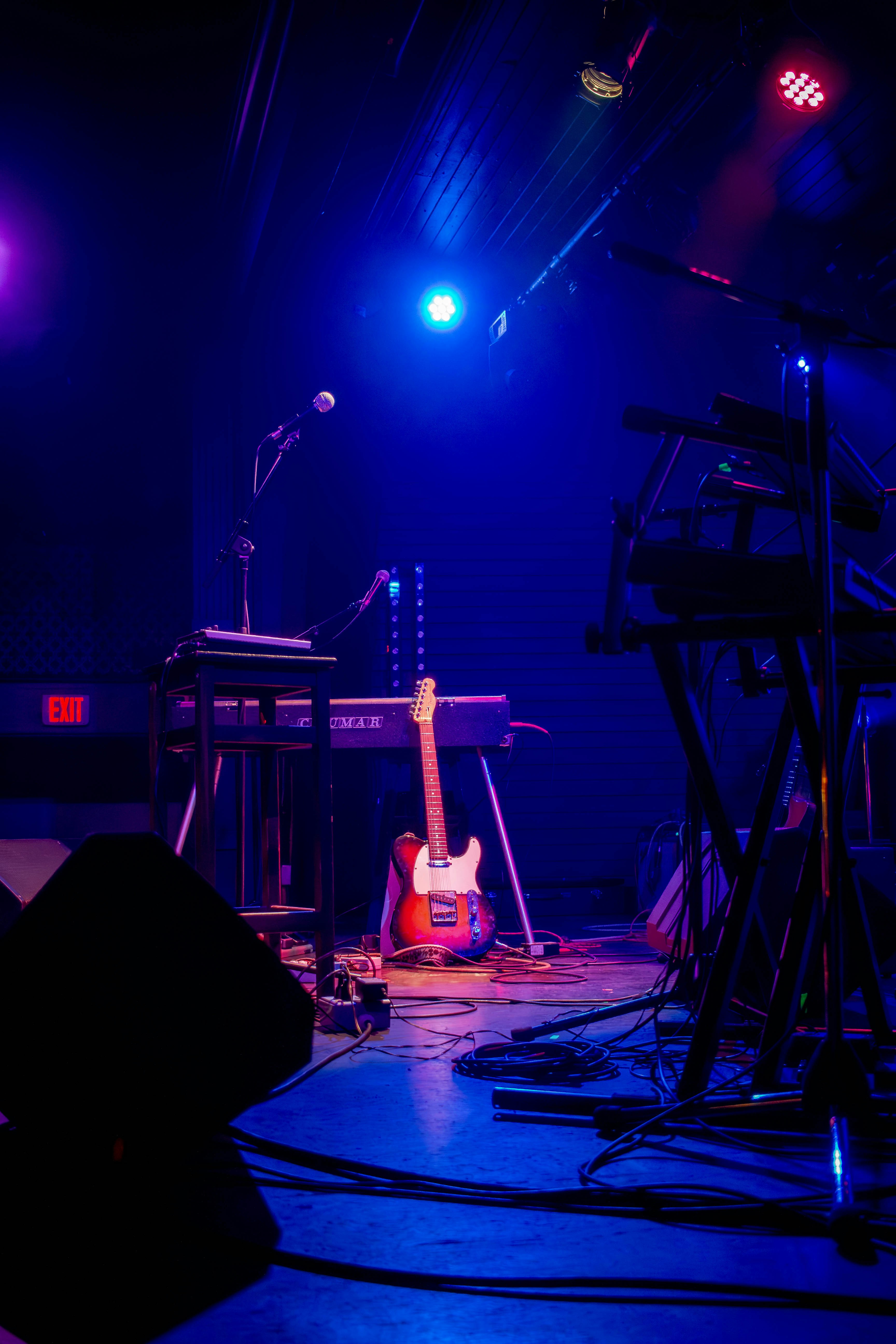 Electric Quiet of a Dim Stage: The Centerpiece Guitar in Blue Nightlight