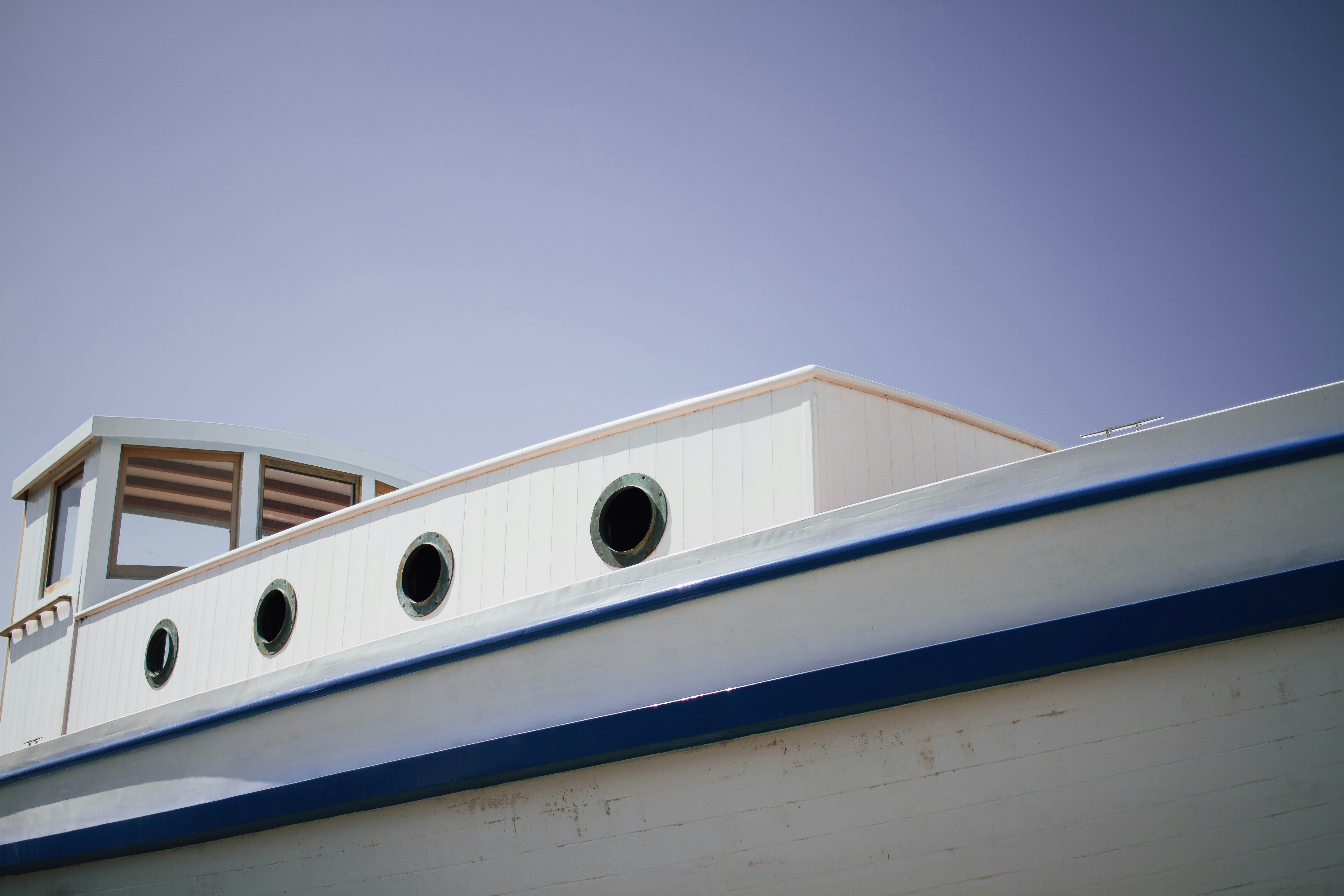 Dockside Vessel Silhouette: A Clean Blue Band Framing a White Hull