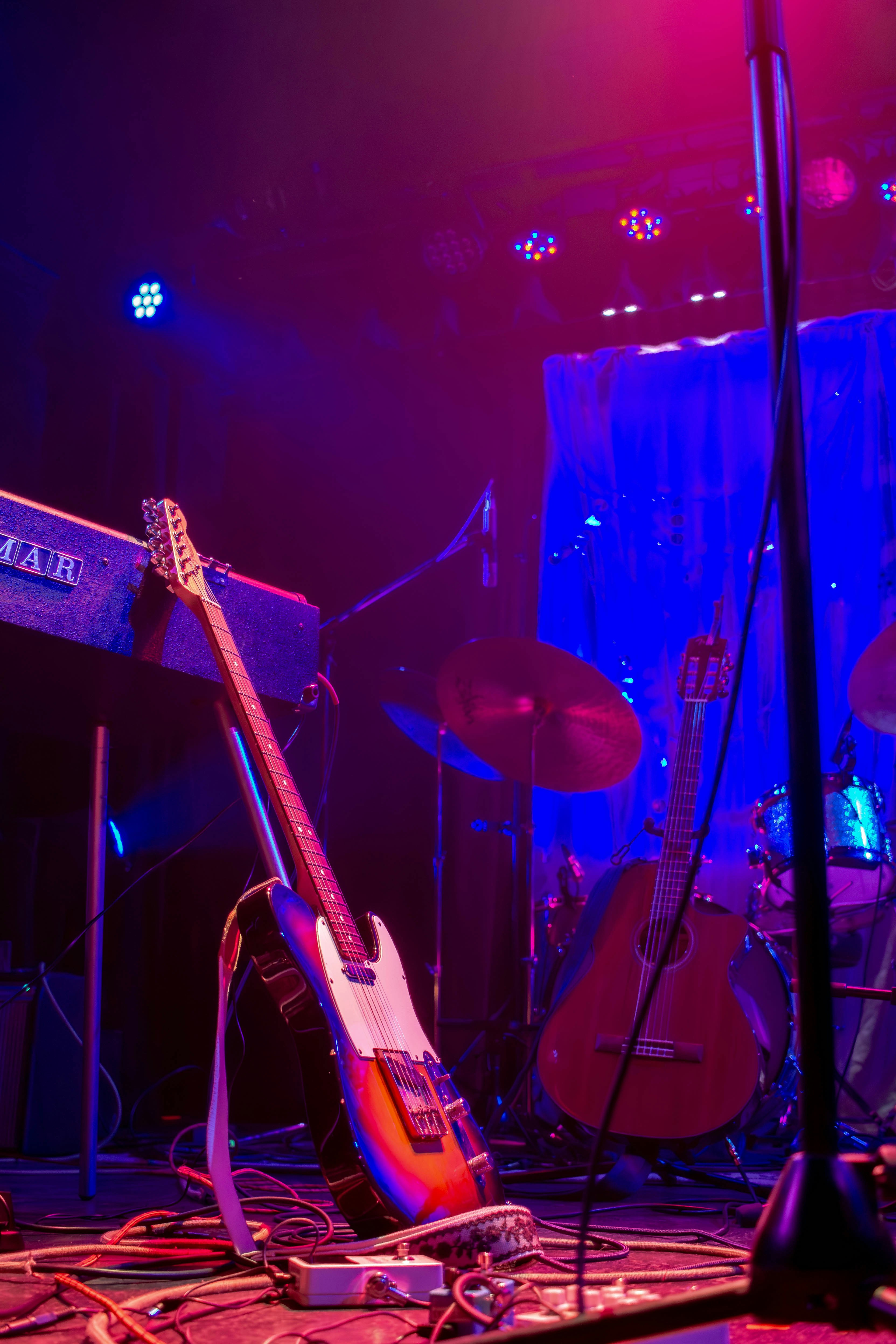 Sunburst Stage: Electric Guitar and Shadowed Drums in a Neon-Lit Set