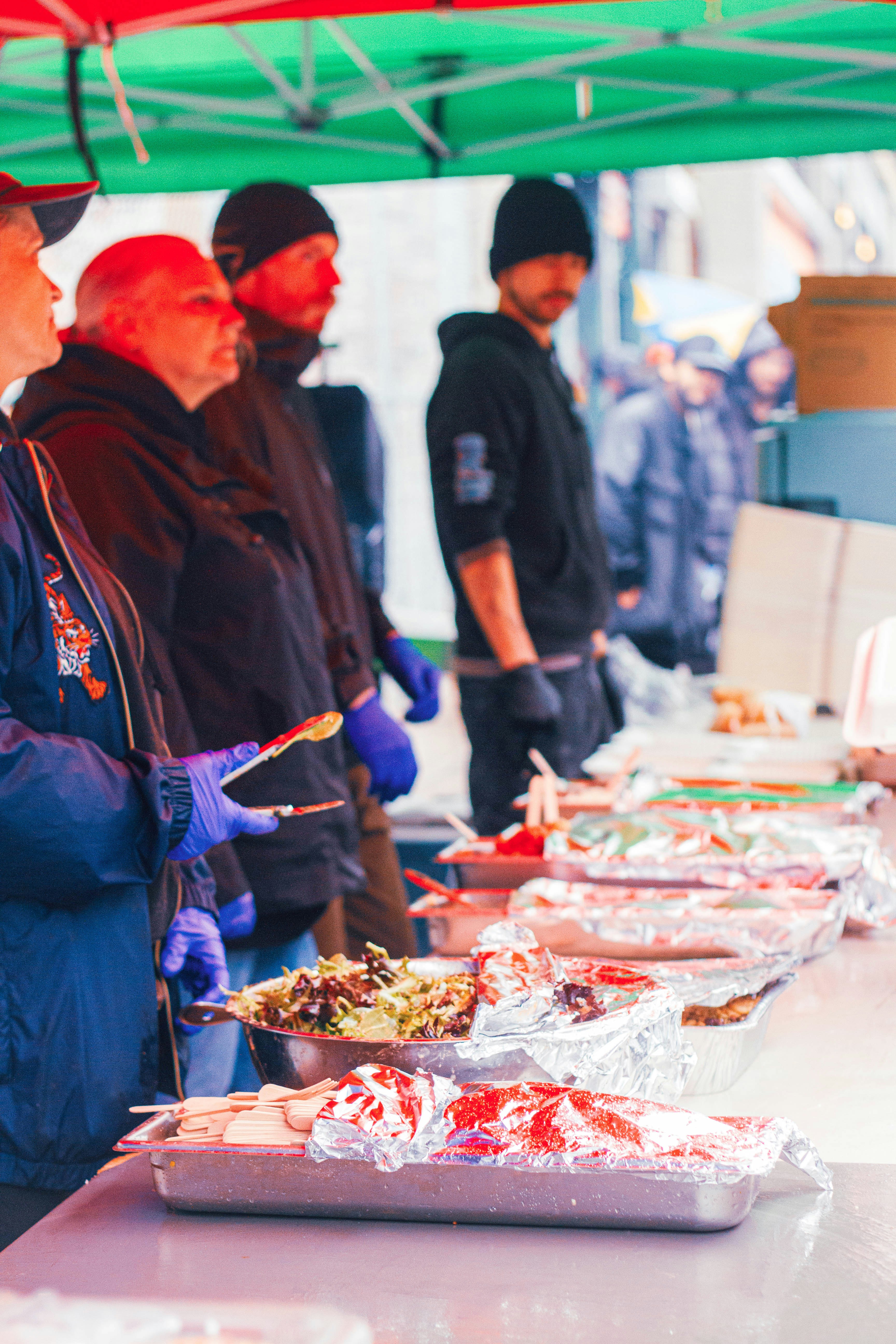 Market Grill Under Neon Canopy: A Row of Chefs at Food Stall