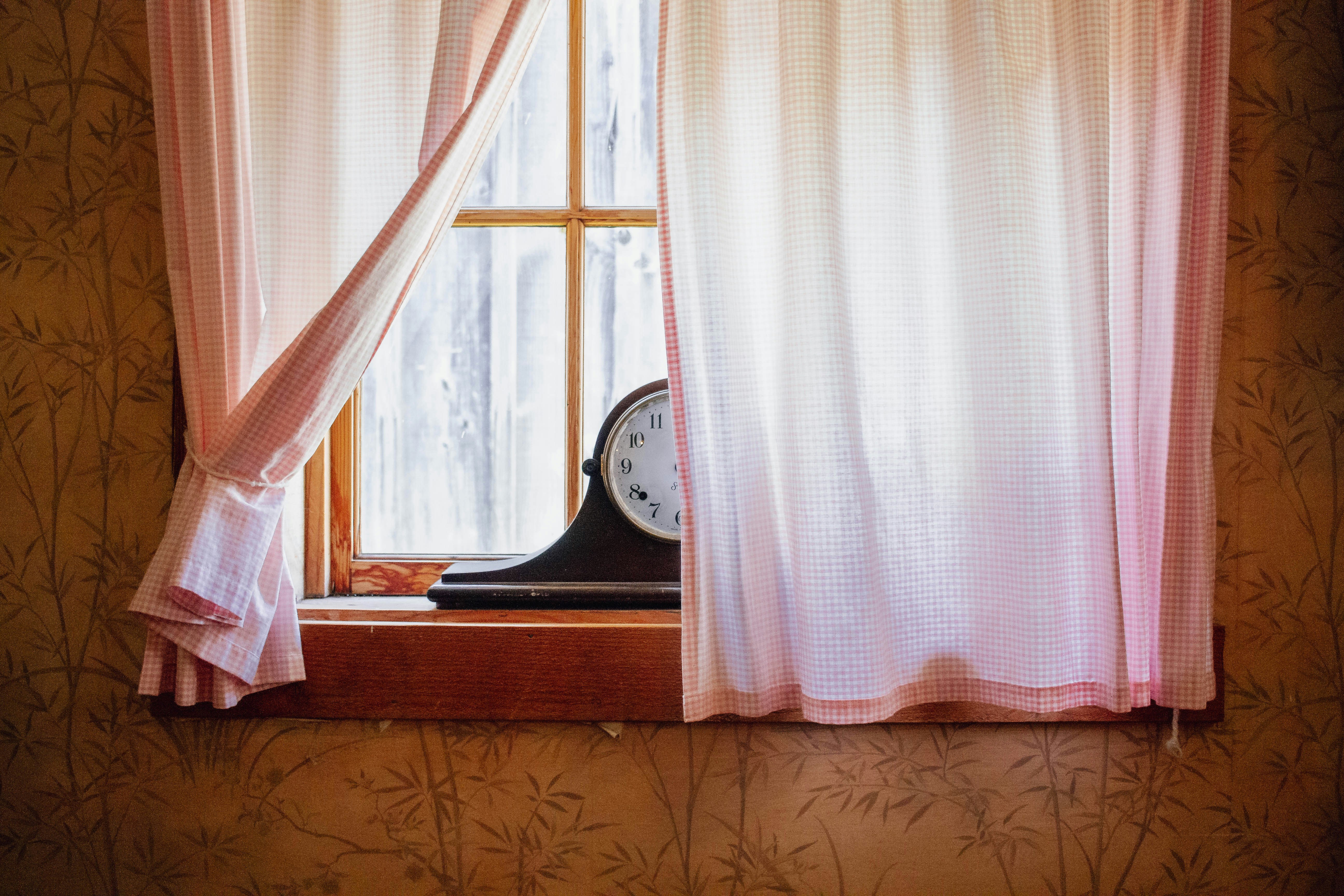 Dusty Sunrise in a Curtained Room with a Mantle Clock