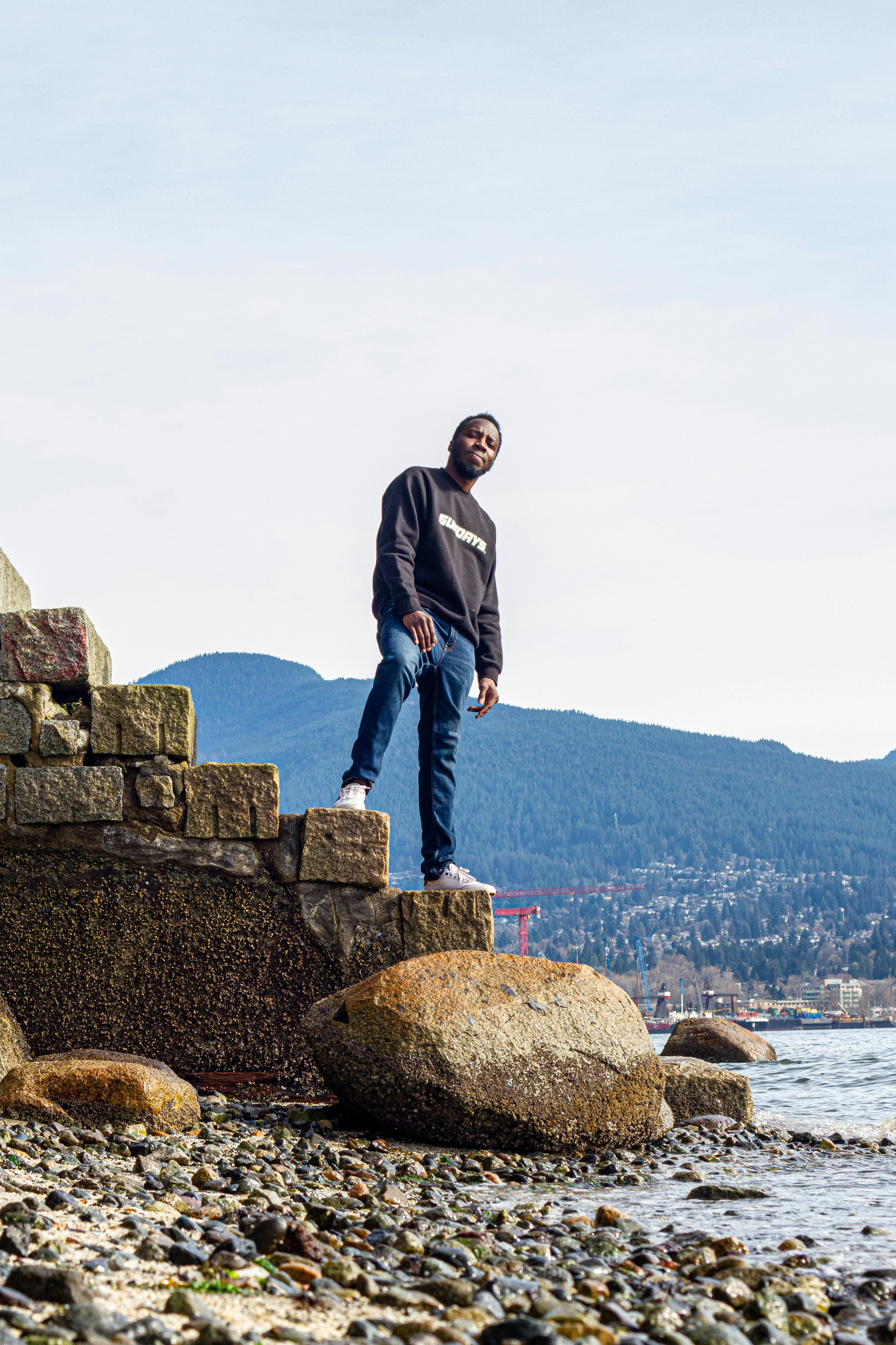Edge of the Tide: A Lone Figure Stands on Weathered Stone
