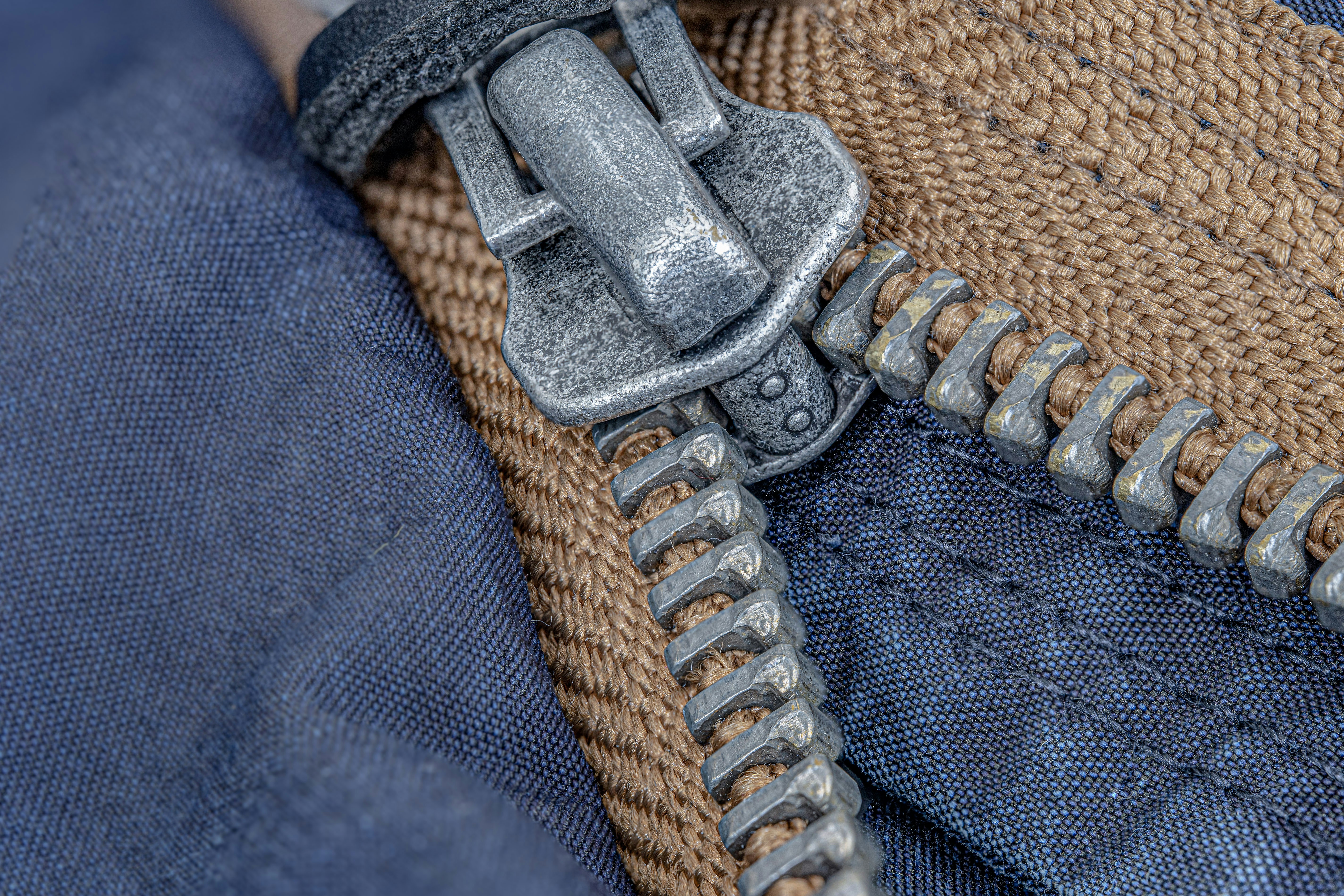 Close-up of a rugged zipper on denim and leather meeting