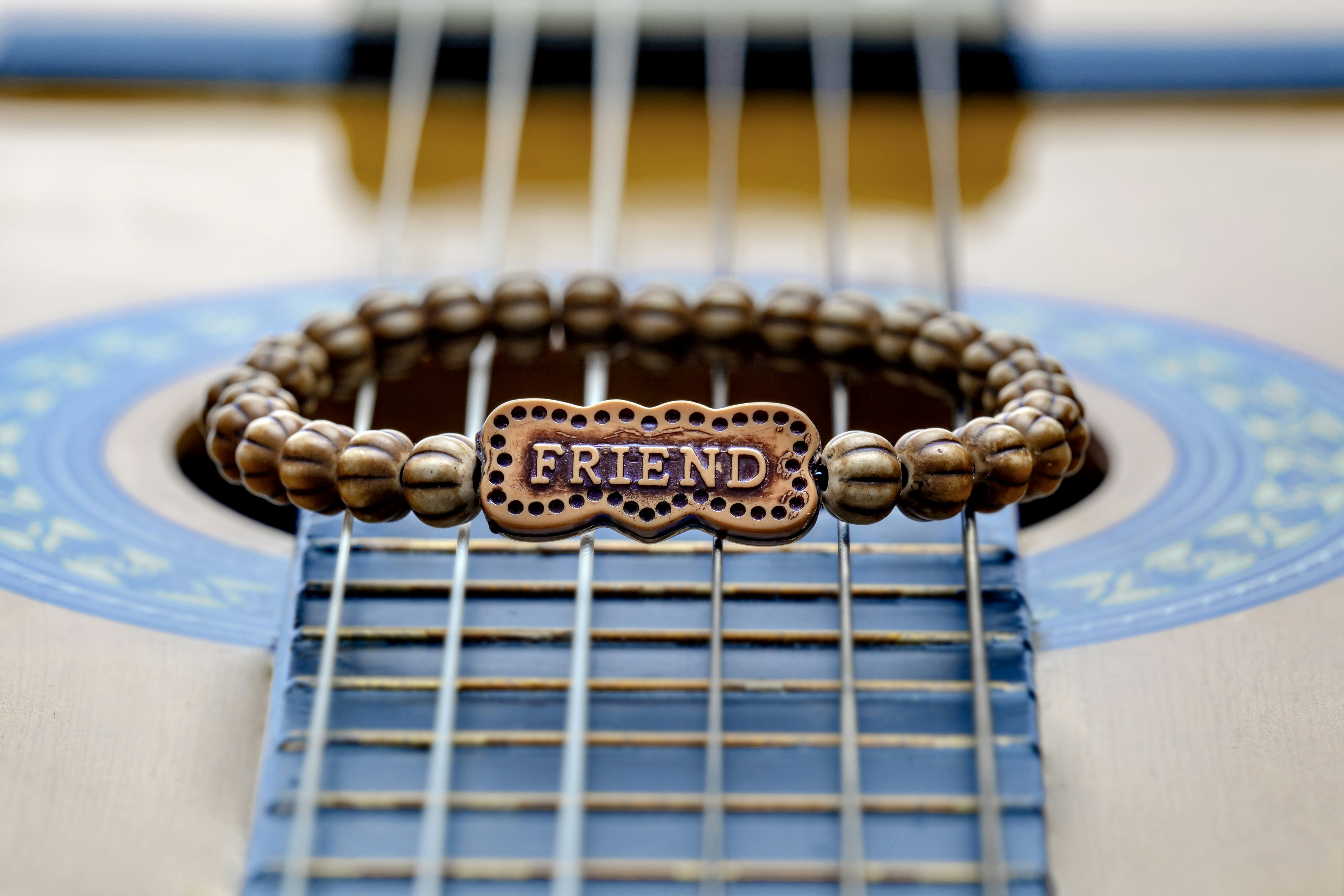 Friendship in Frets: A Beaded Bracelet Resting on an Acoustic Guitar