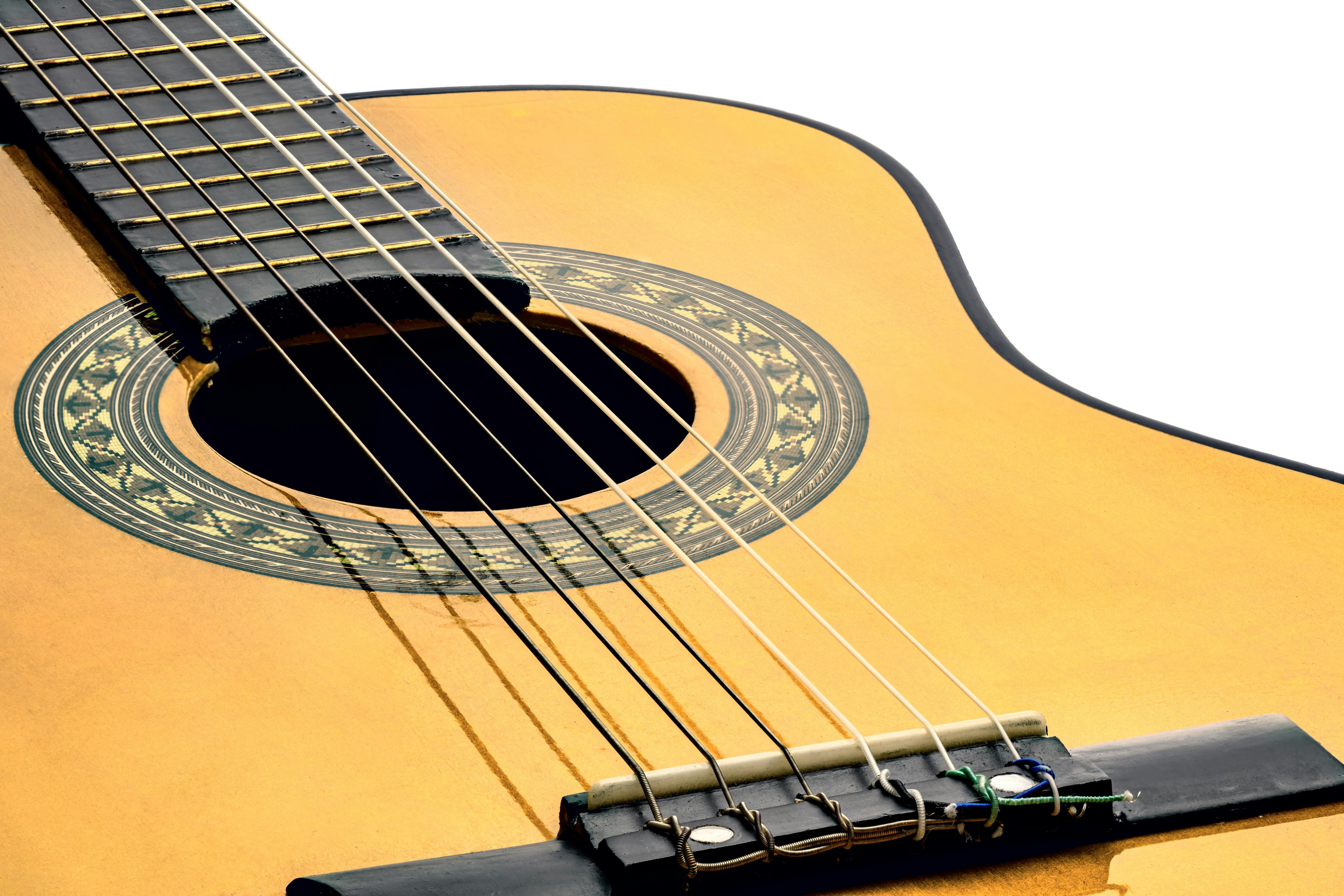 Close-up of a classical guitar: strings tracing a quiet arc over the rosette