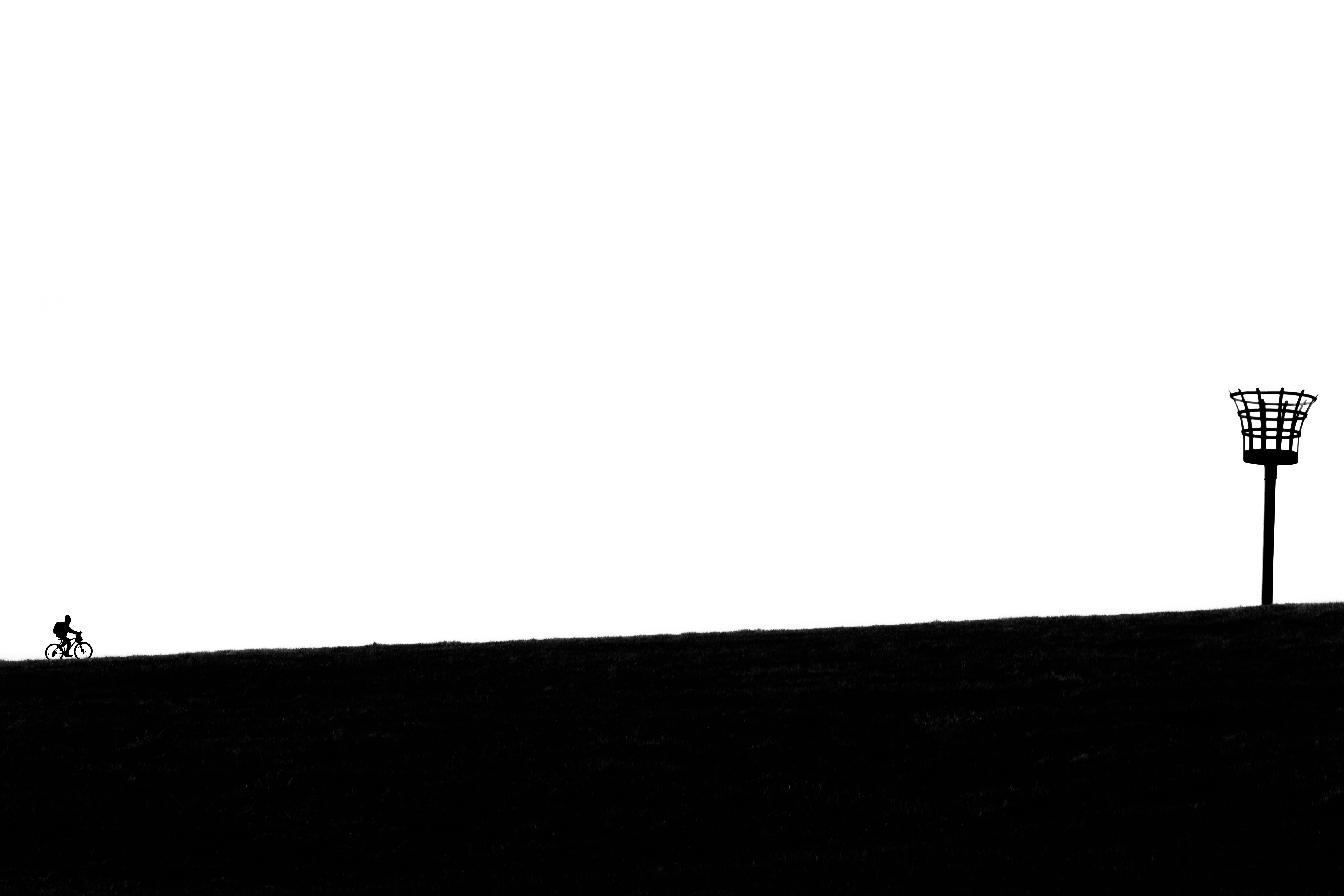 Silhouette on a Crest: A Lone Cyclist Near a Towered Horizon