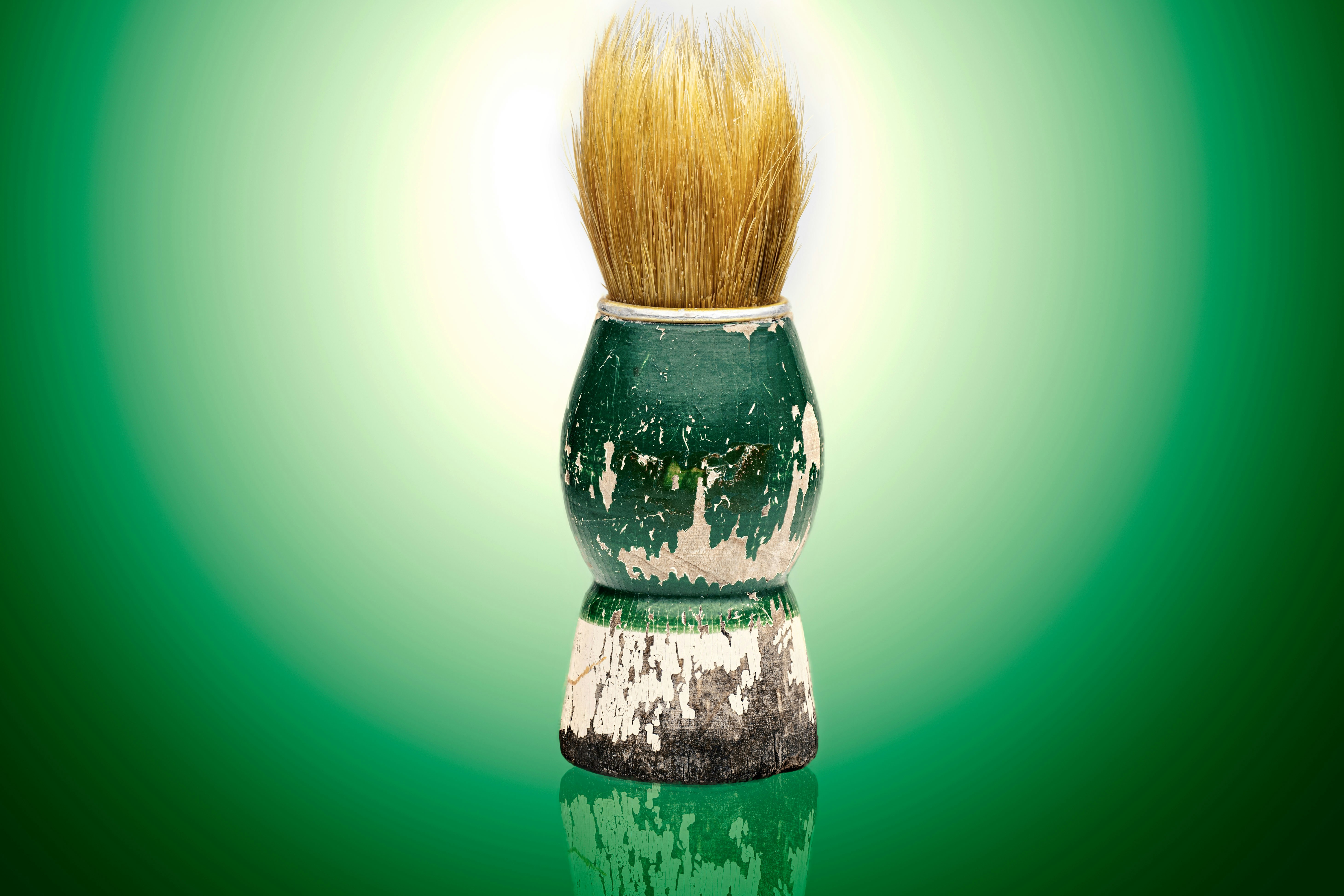 Centered Bristle: A Weathered Brush Emerges from a Green Glow