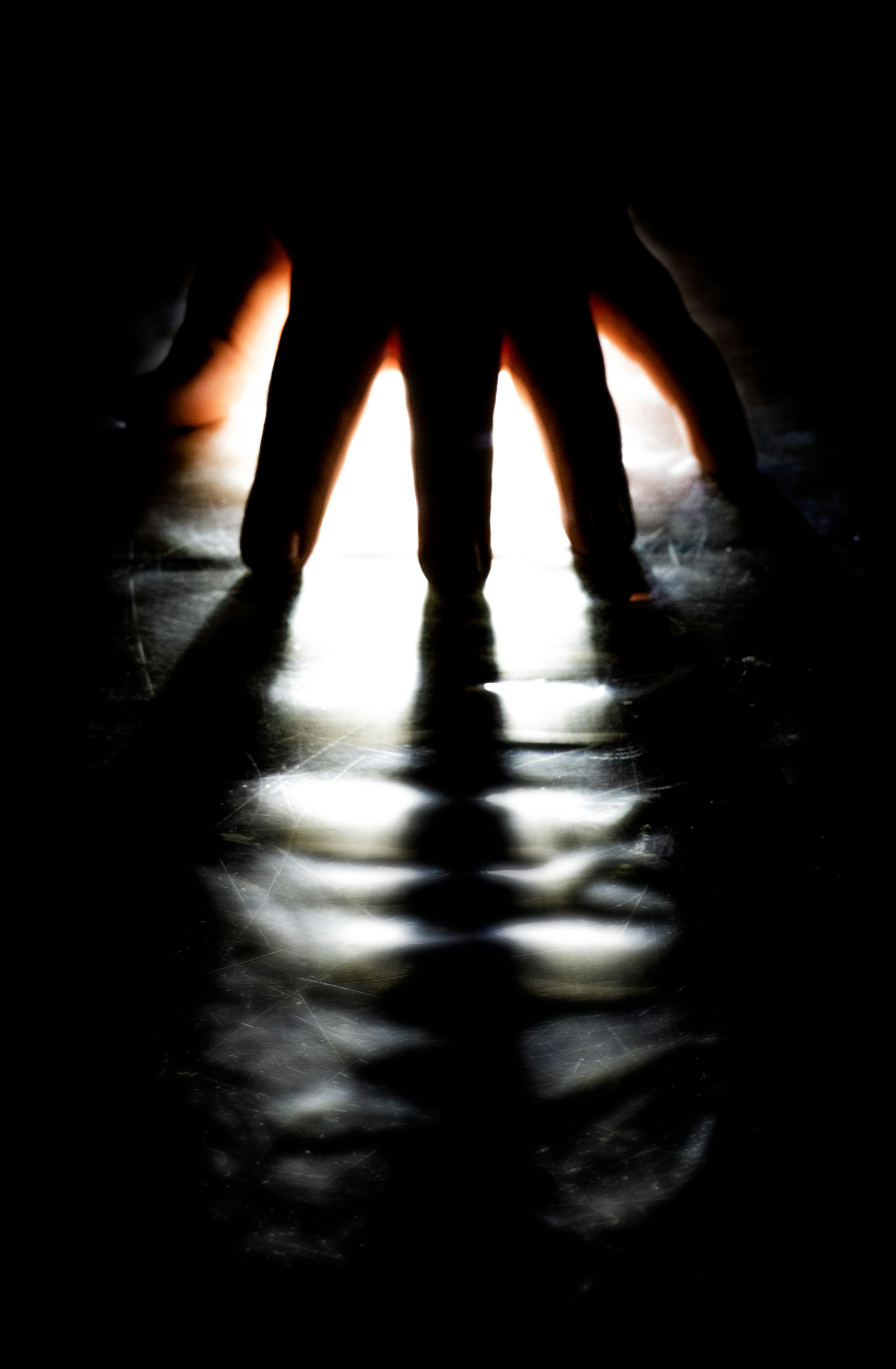 Silhouette of a Hand Reaching Toward Dawnlit Floor