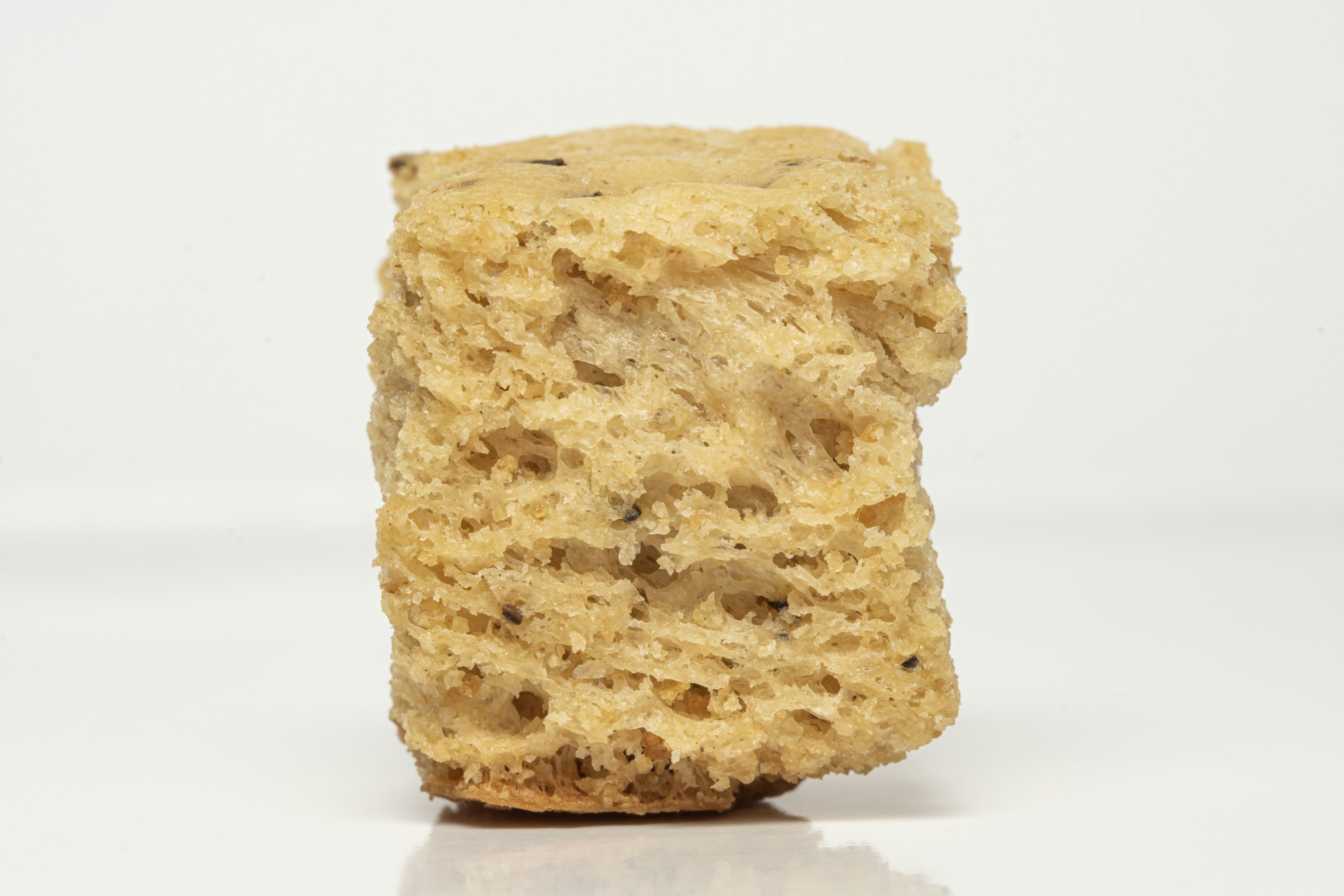 Airy Micro-Loaf: A Solo Slice on a Stark White Stage