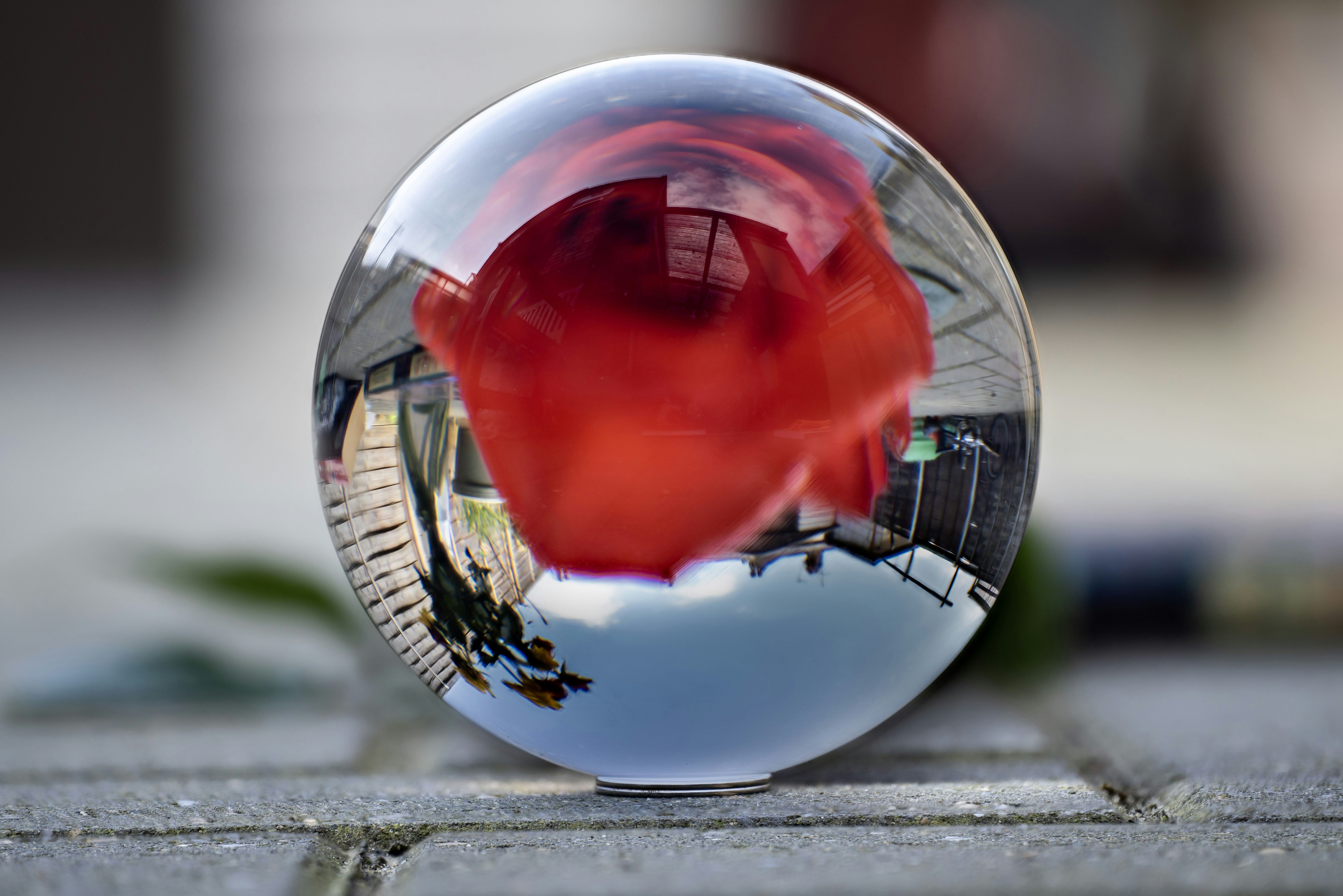 Red Globe, Sharp Focus: A Glass Sphere Containing a blurred Urban Reflection