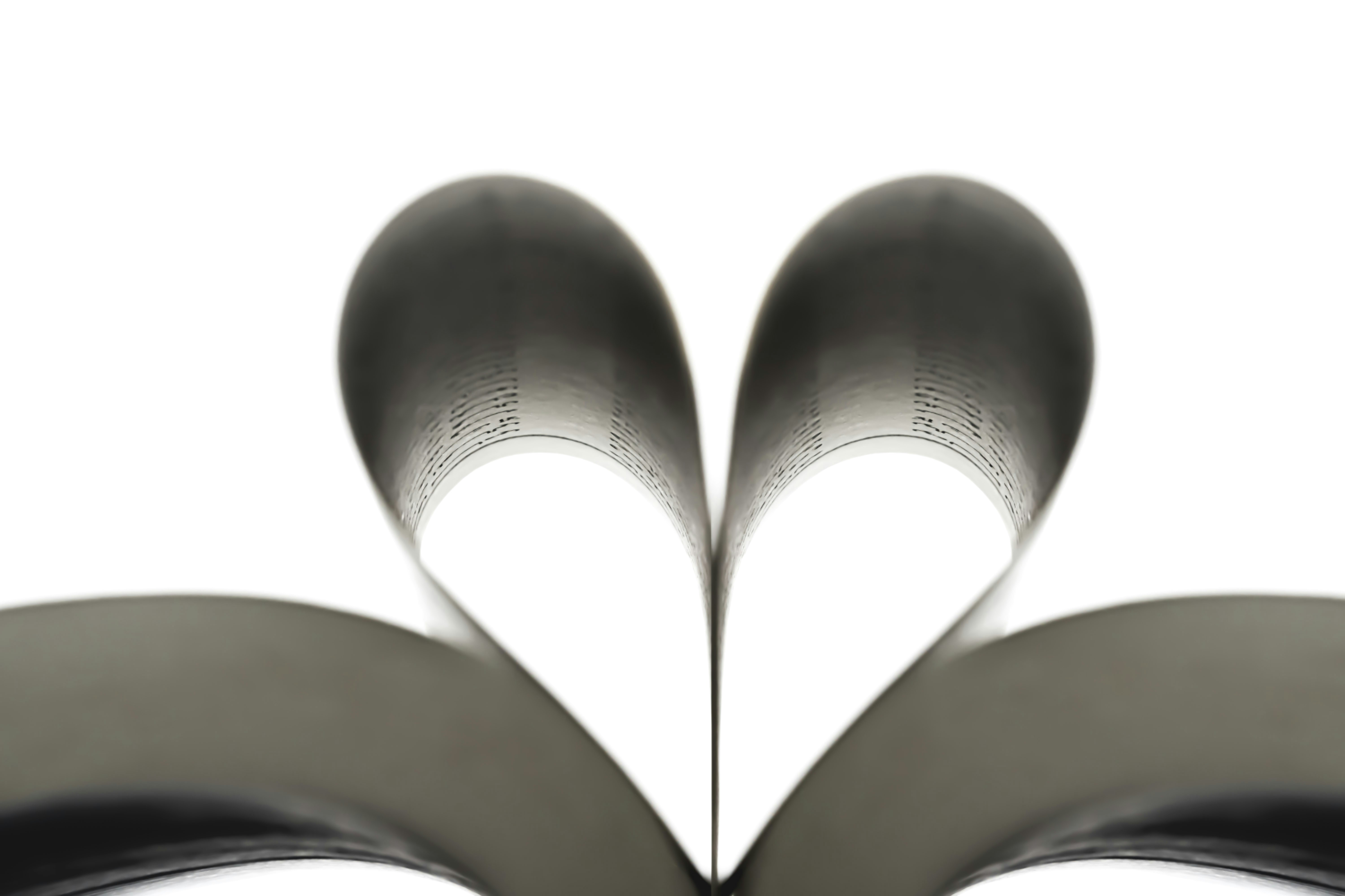 Curved steel symphony: a heart formed from folded ribbons