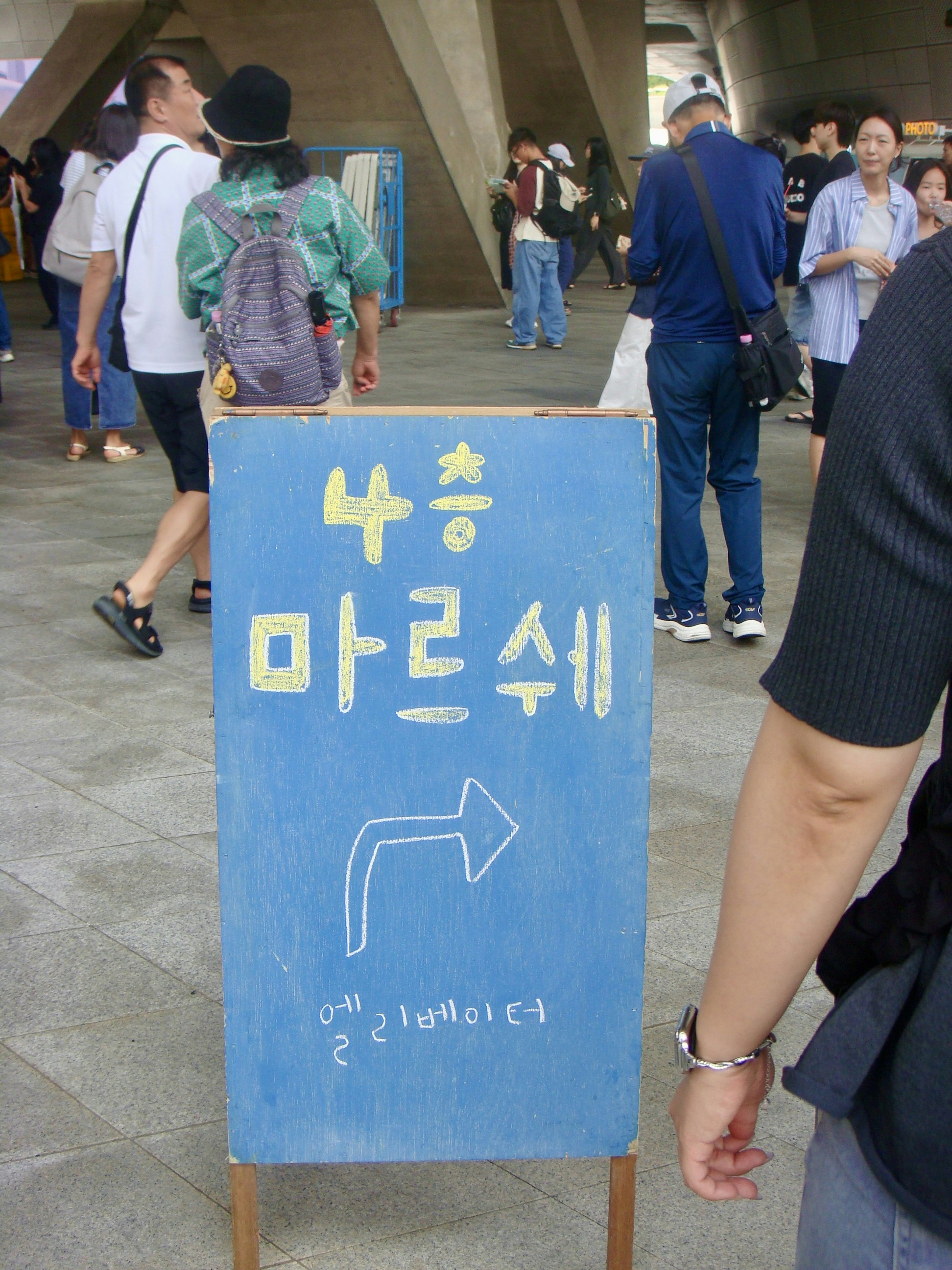 Blue Signpost in Public Square with Korean Script