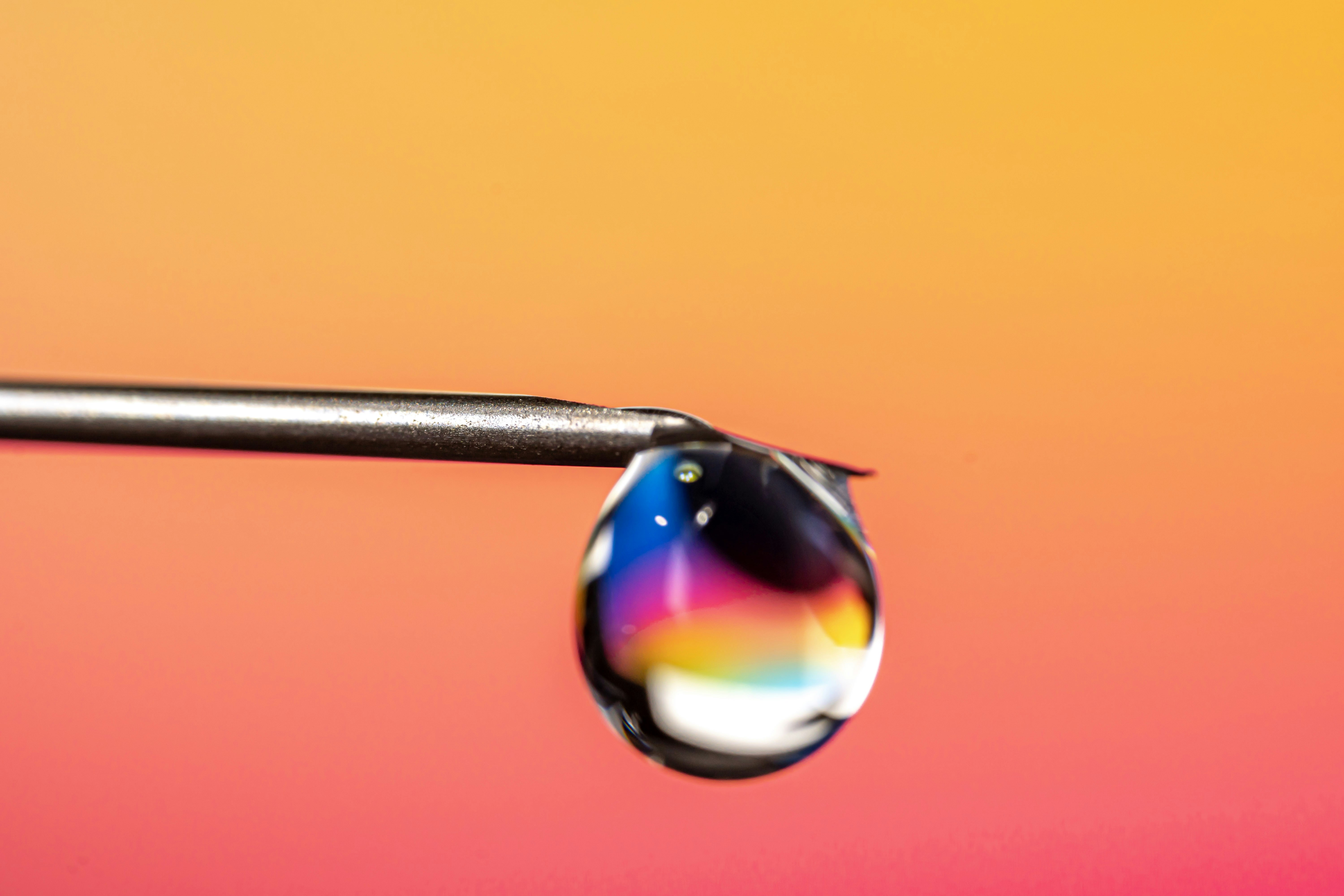 Liquid Prism on a Pin: A Droplet Gripping the Sunset