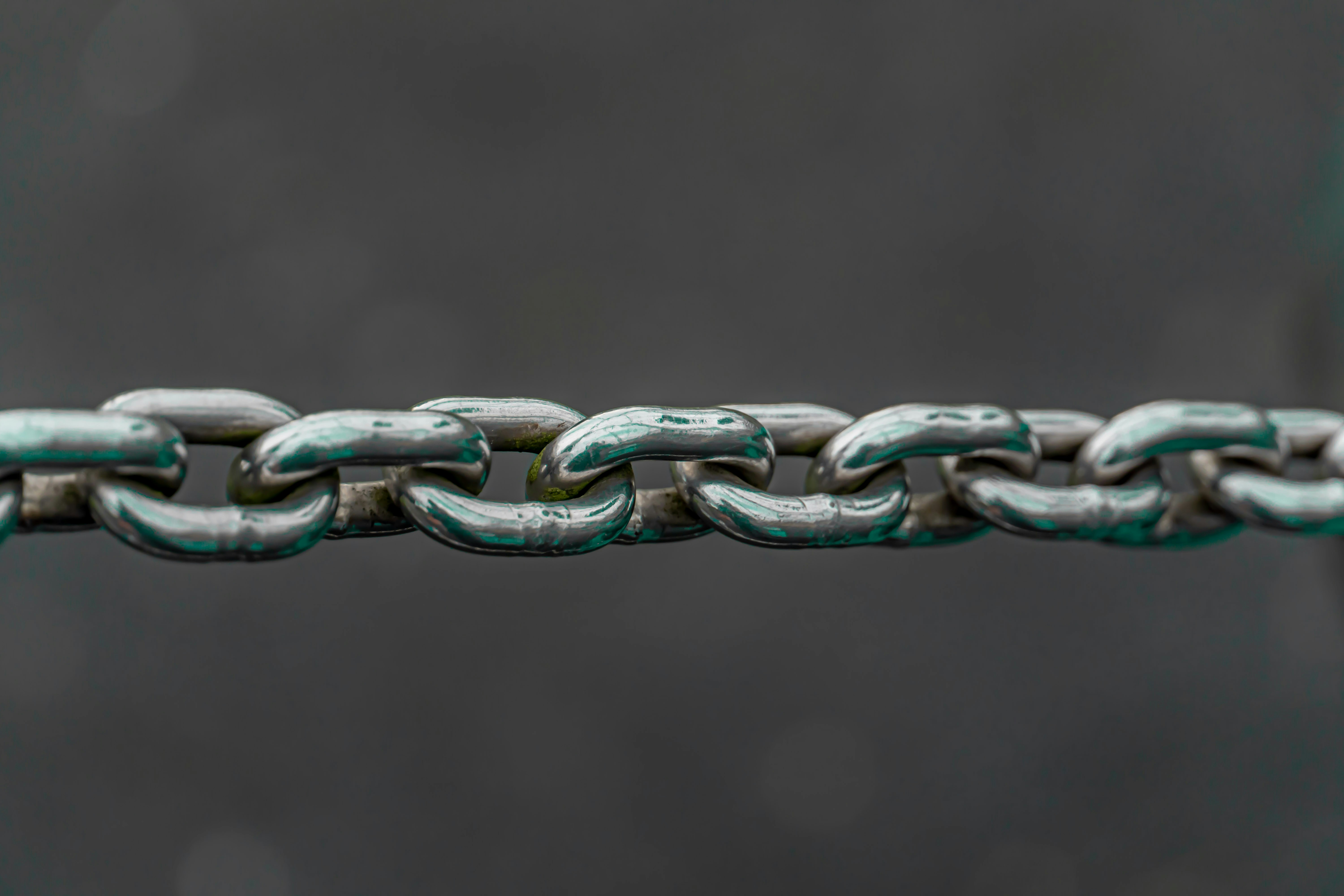 Weathered links: a close-up of a desaturated chain's texture